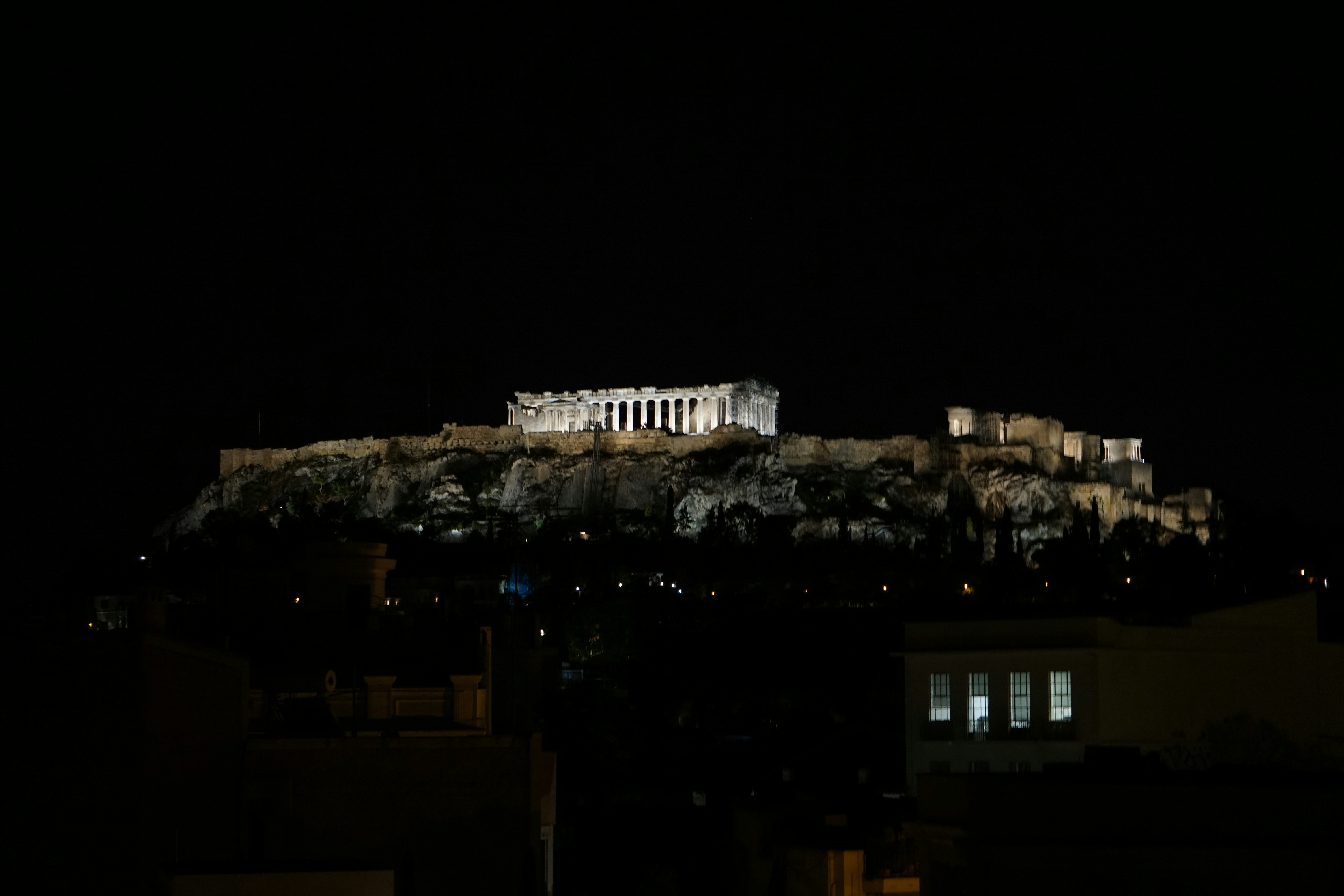 Acropolis of Athens illuminated against a night sky, showcasing its historical architecture and significance.