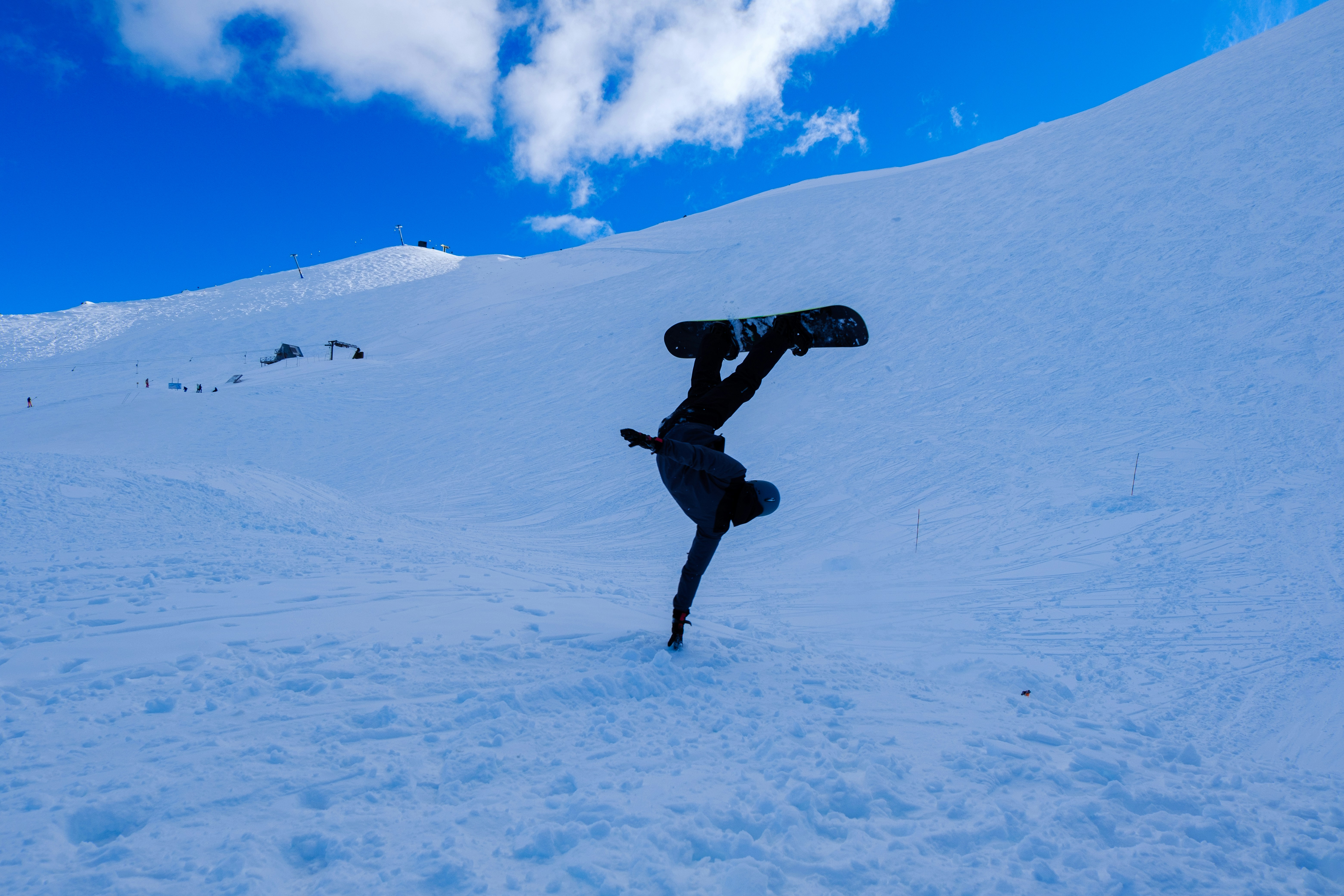 Inverse Snowboard Trick on a Quiet Alpine Slope Beneath Cerulean Sky