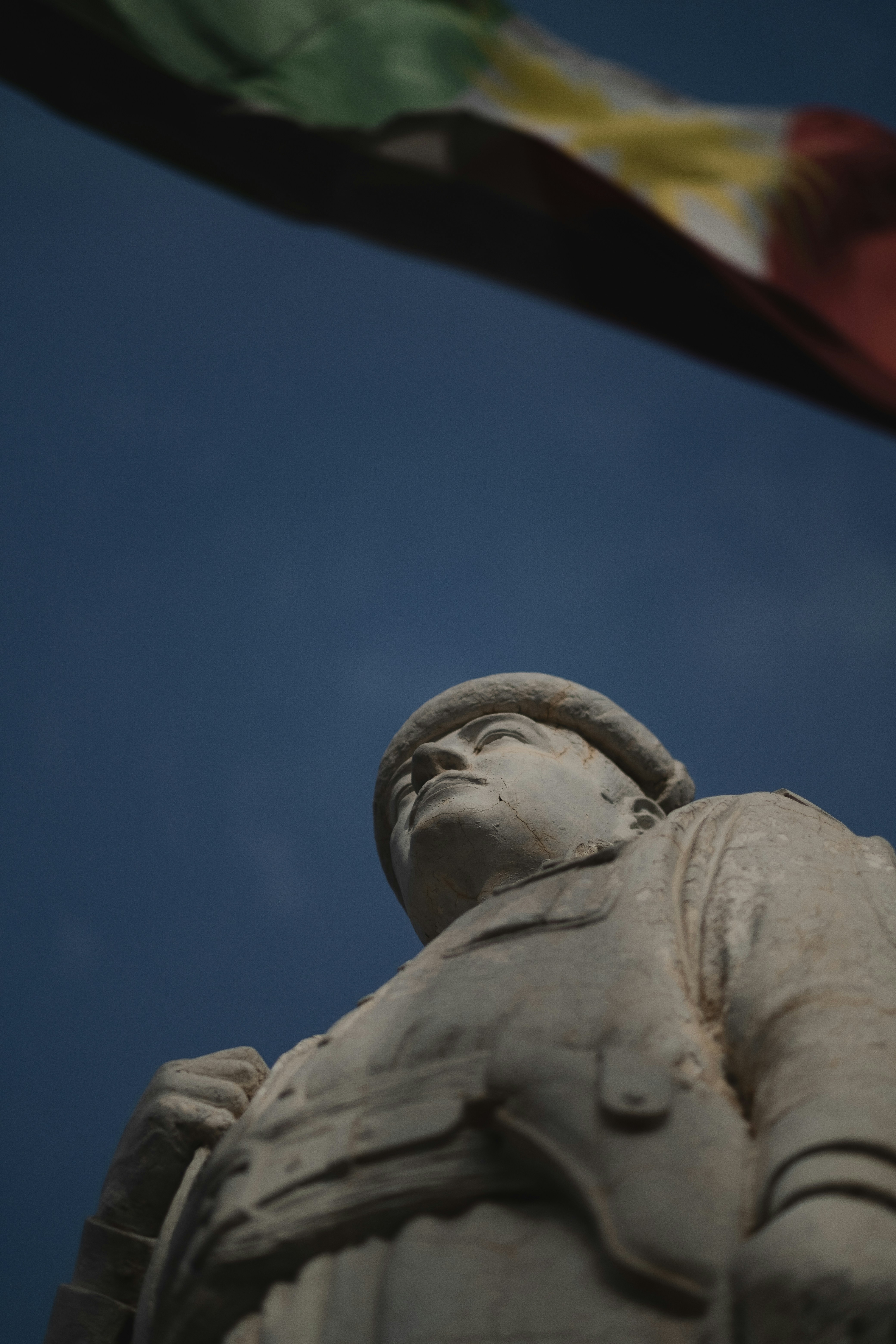 A statue with a flag flying in the background photo – Free Shekhan ...