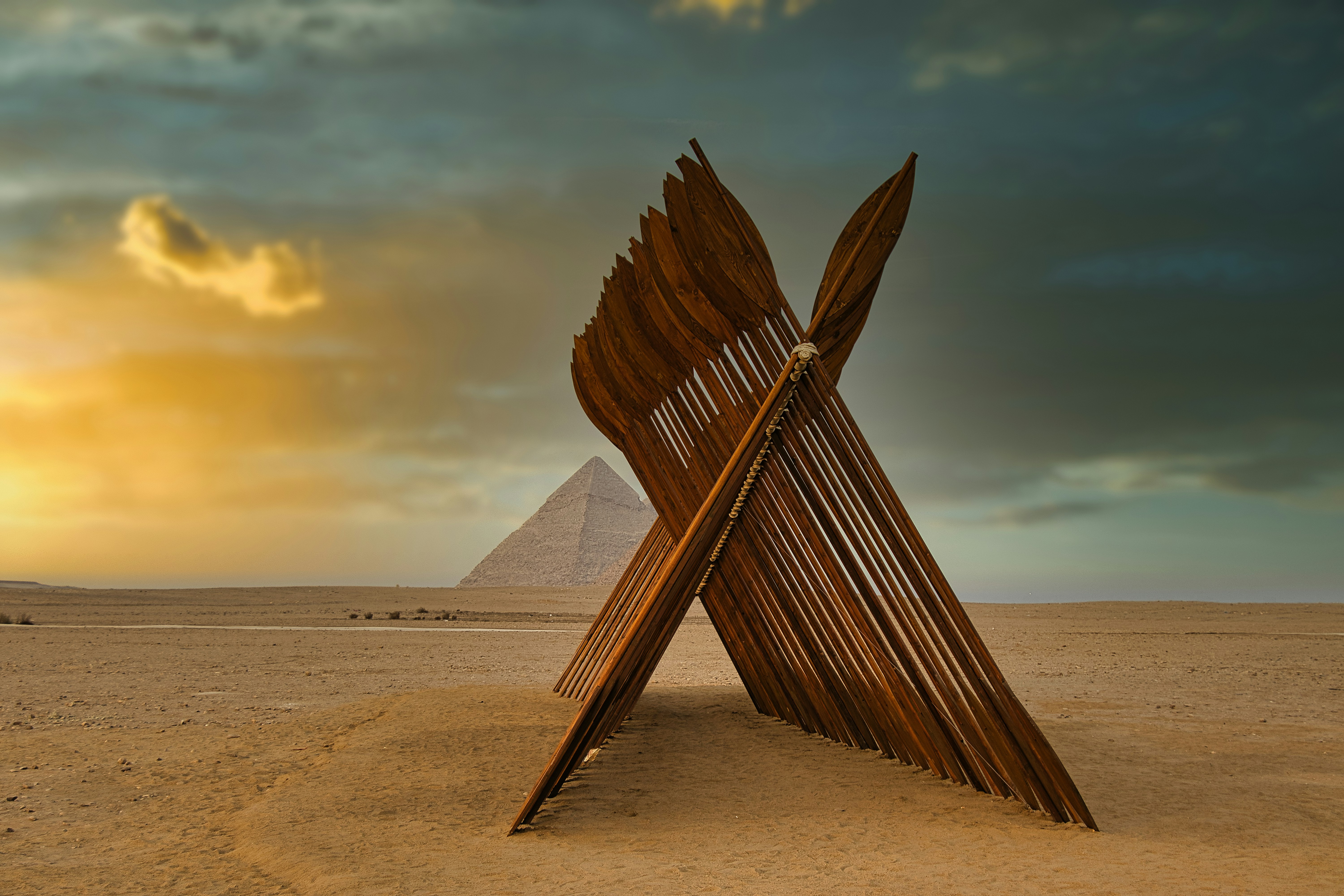 Crossed Timber Monument at Dusk: Desert Winds and Pyramid Silhouette