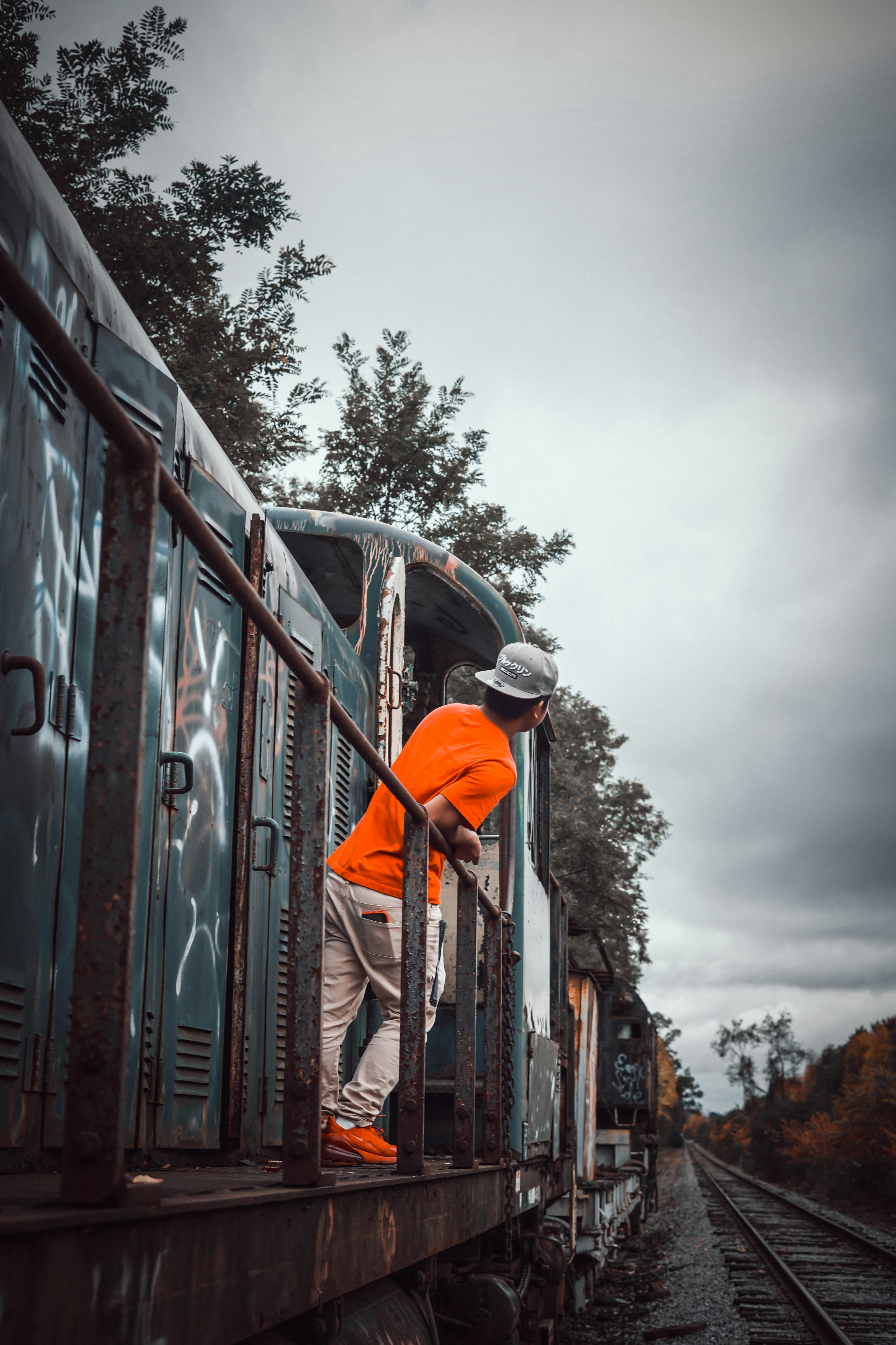 Orange-Top Contrast: A Worker Locking Eyes with the Moving Train