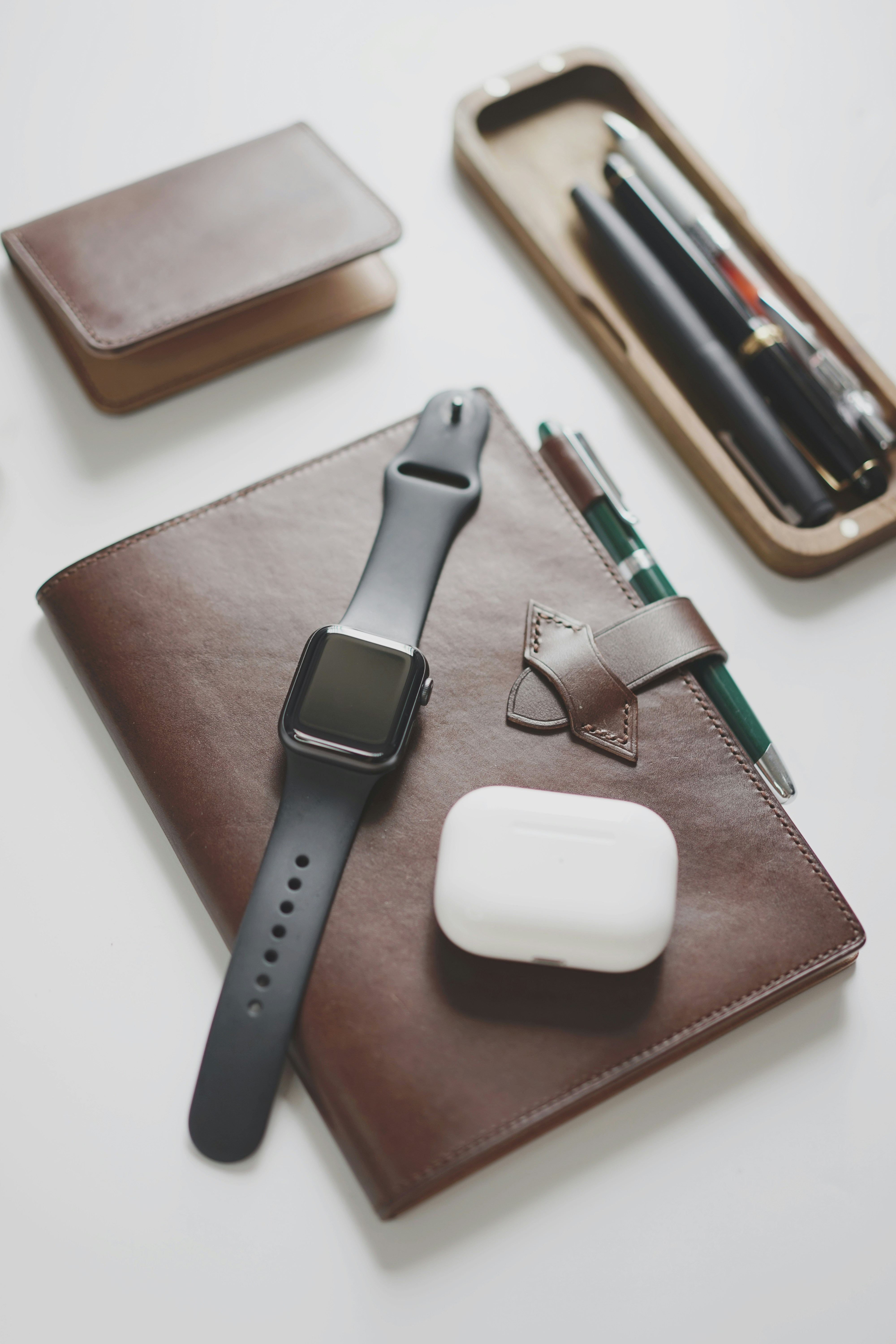 An apple watch, pen, and wallet on a table photo – Free Grey Image on ...