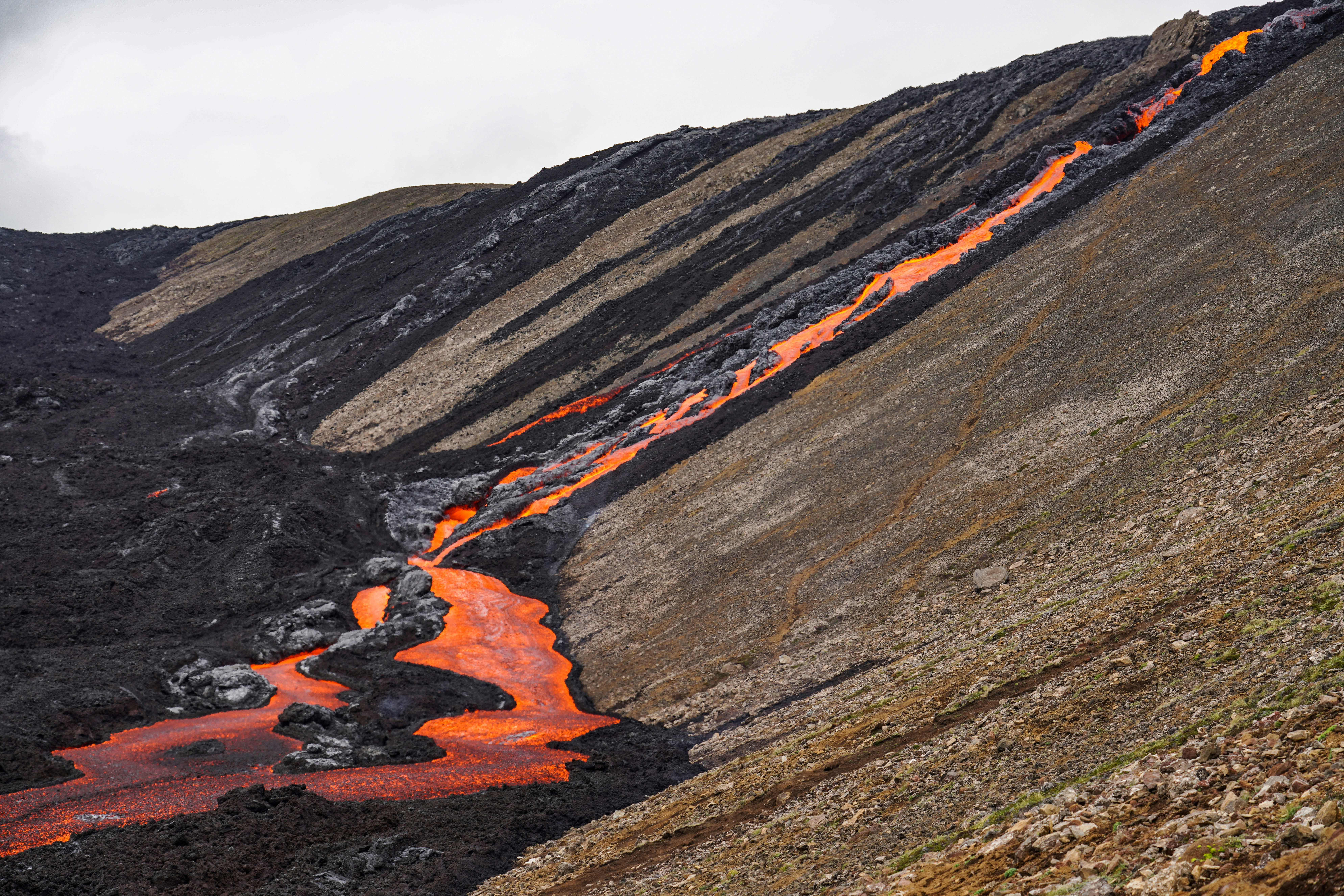 An orange stream of water flowing down a mountain side photo – Free ...