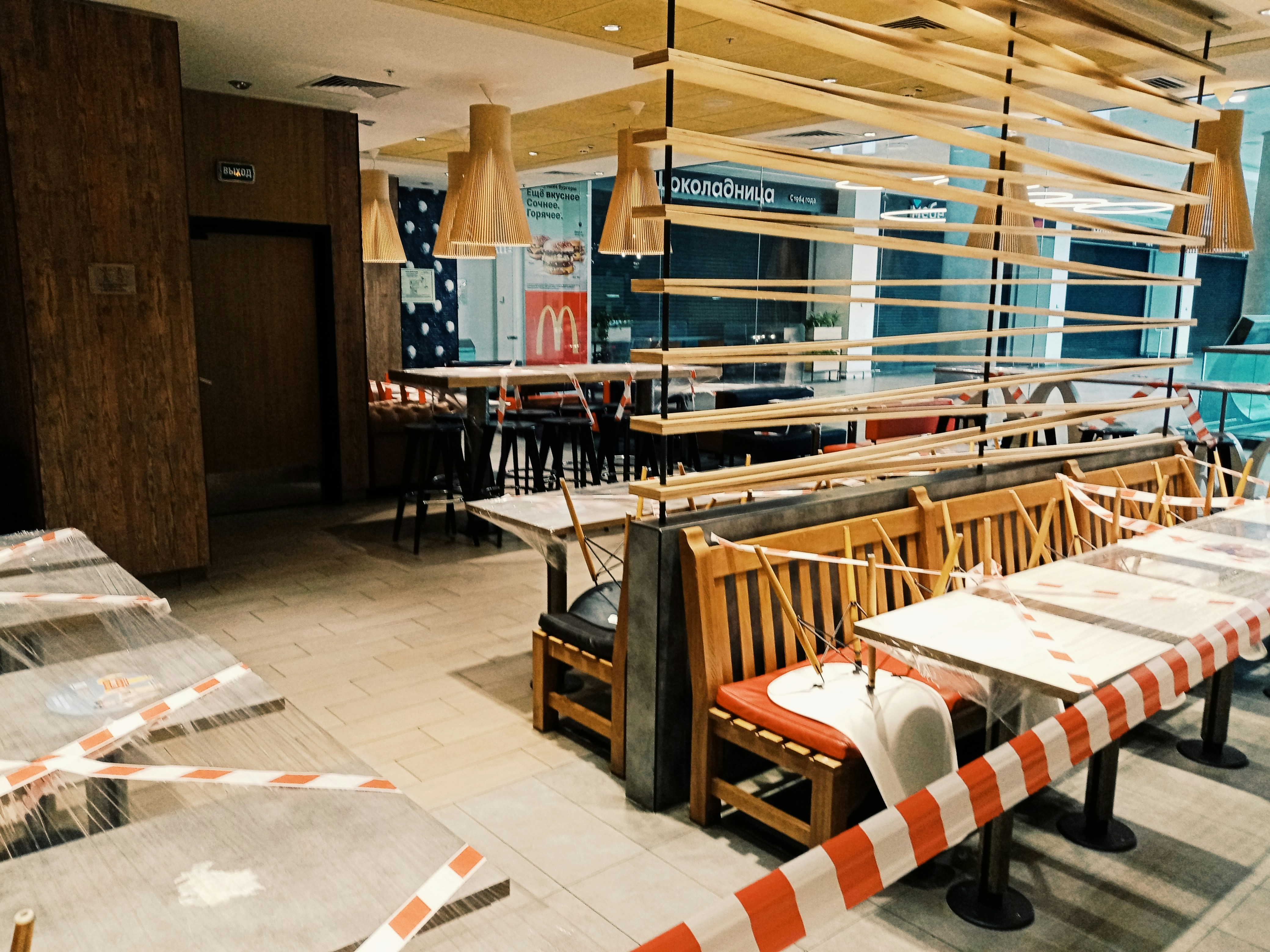 Un restaurante con mesas y bancos con barreras a rayas naranjas y ...