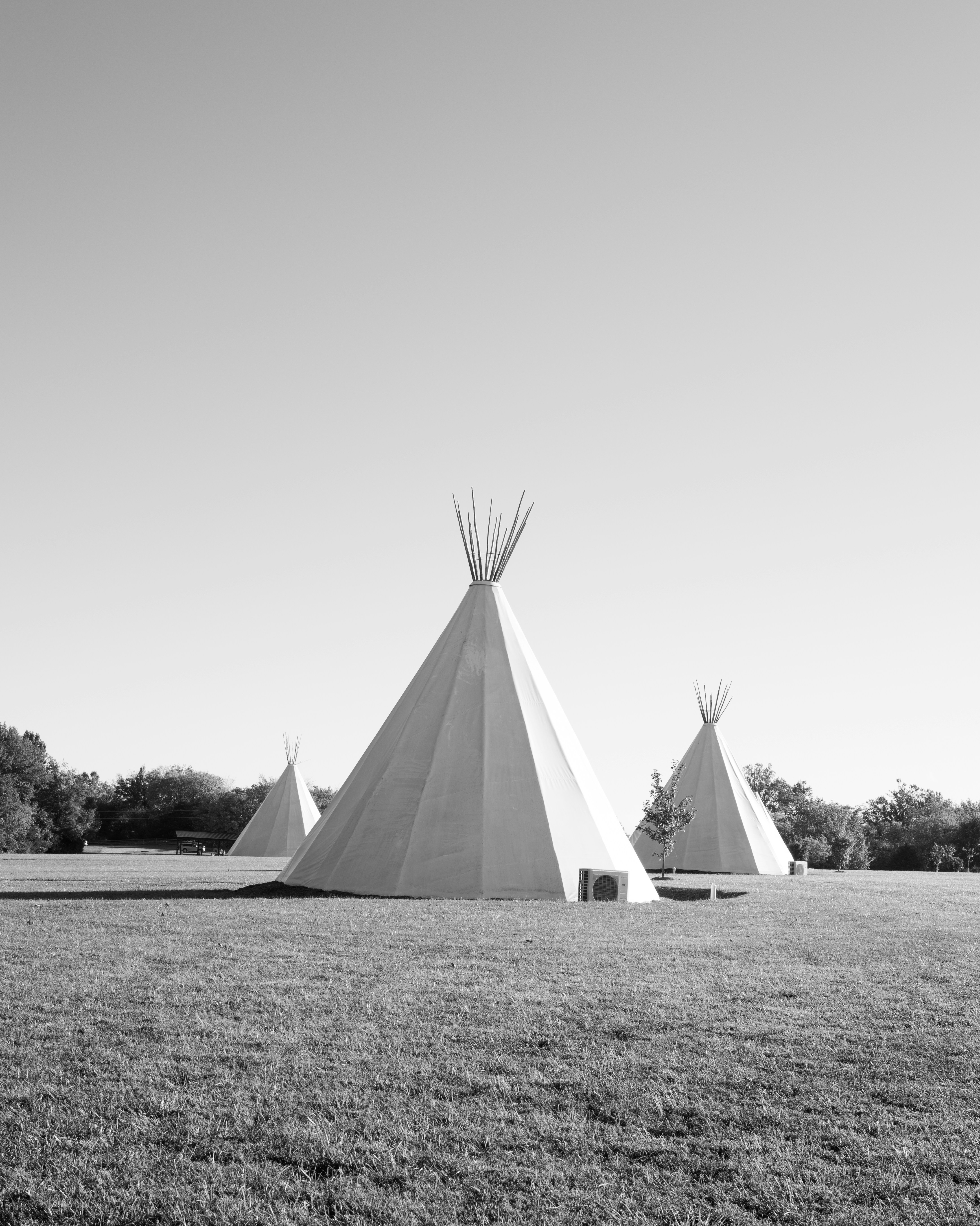 A black and white photo of three teepees in a field photo – Free ...