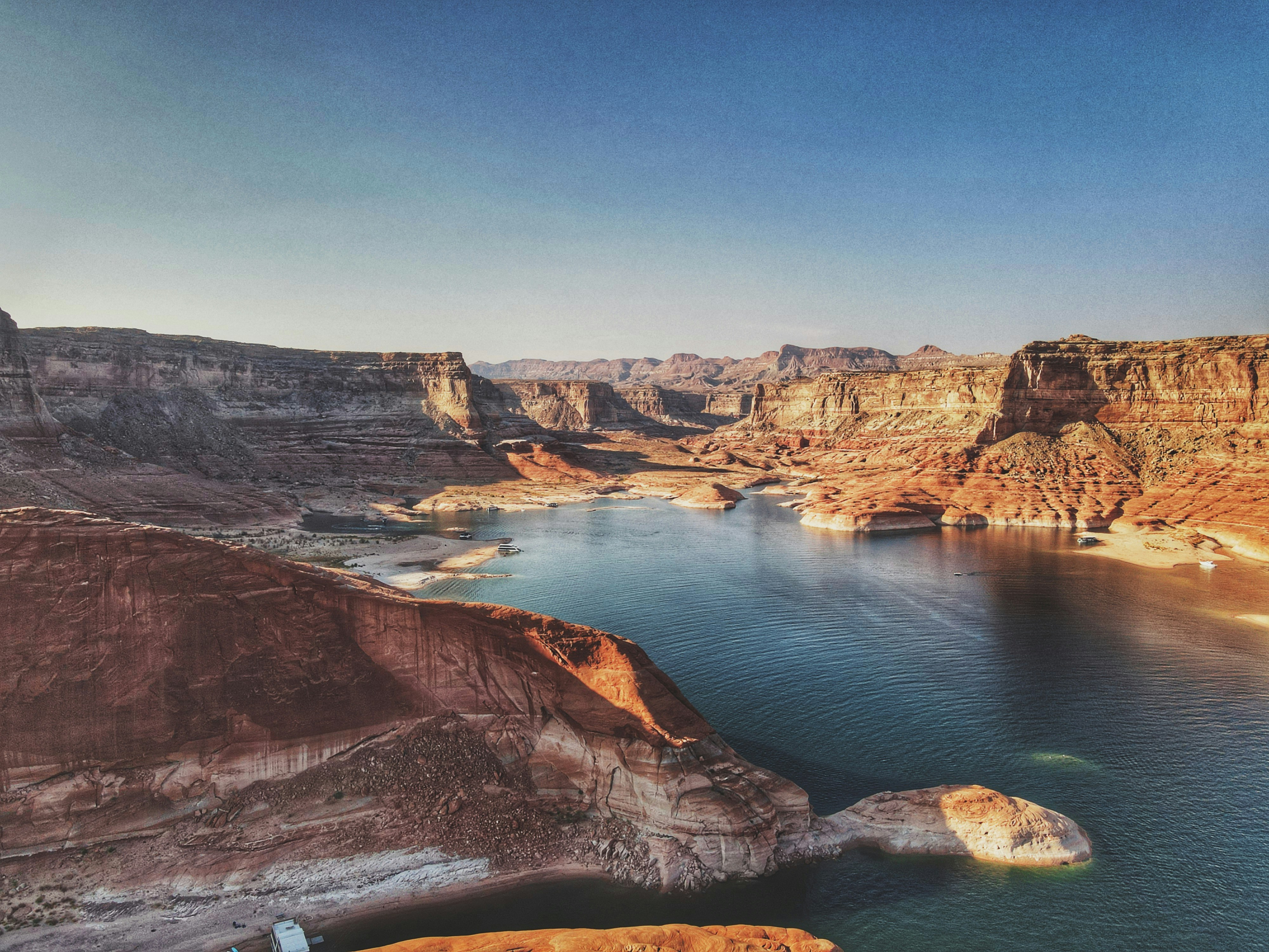 Expansive canyon landscape with winding river and rugged cliffs under a clear sky.