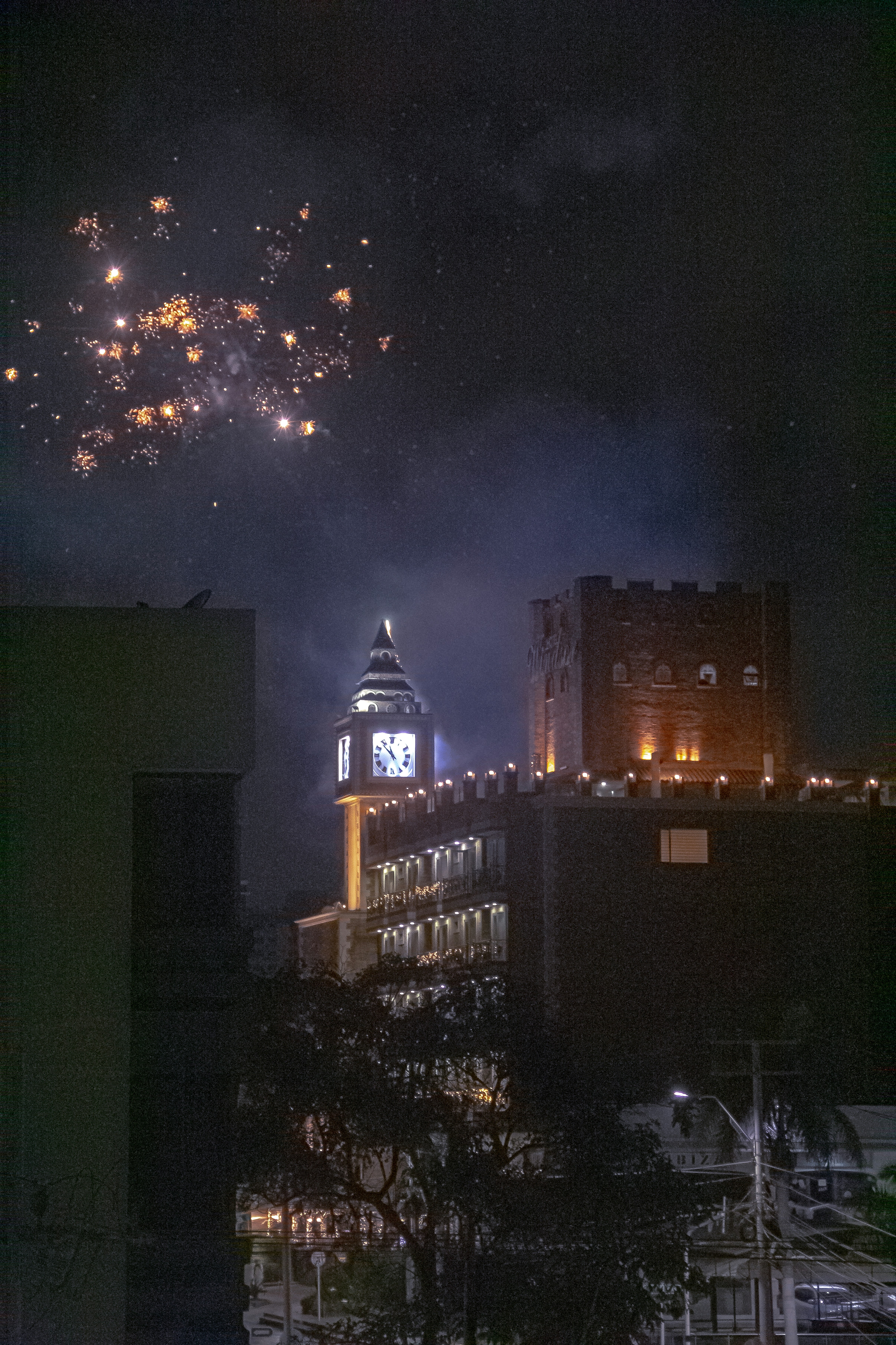 Clock Tower Lanterns Over a Firework-Kissed City Night