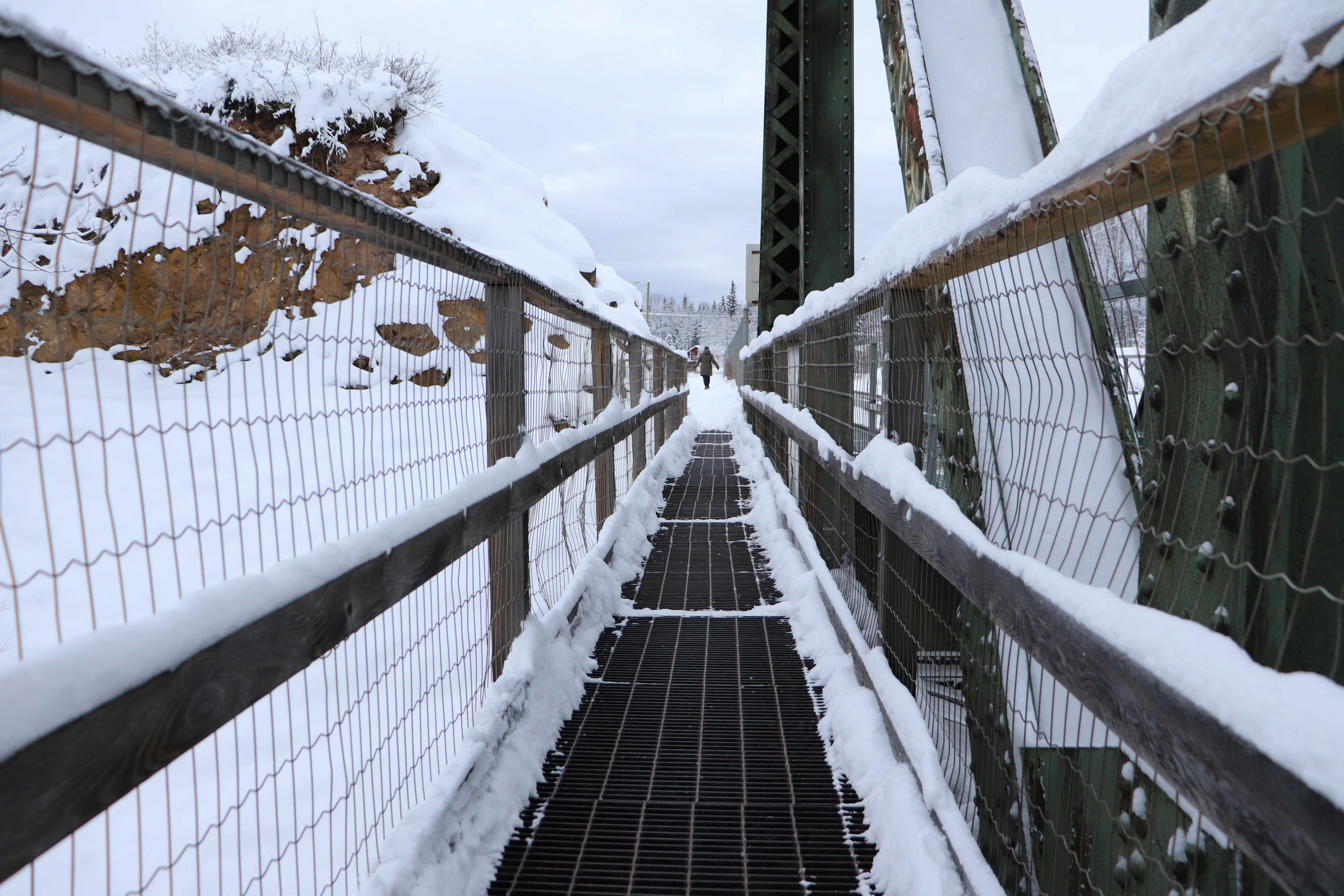 a bridge that is covered in snow on a cloudy day