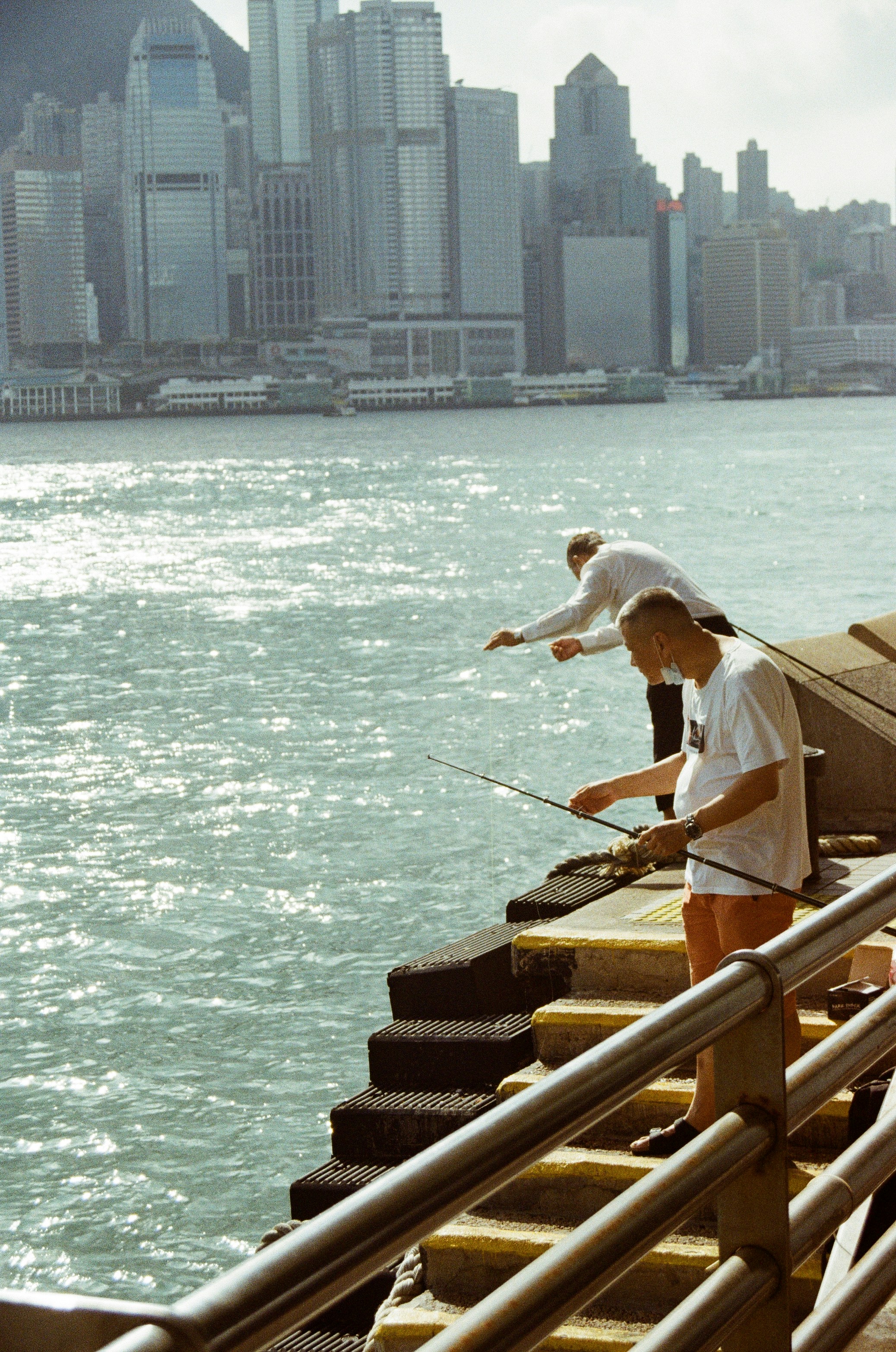Foto Dos personas pescando en un muelle cerca del agua – Imagen Agua ...