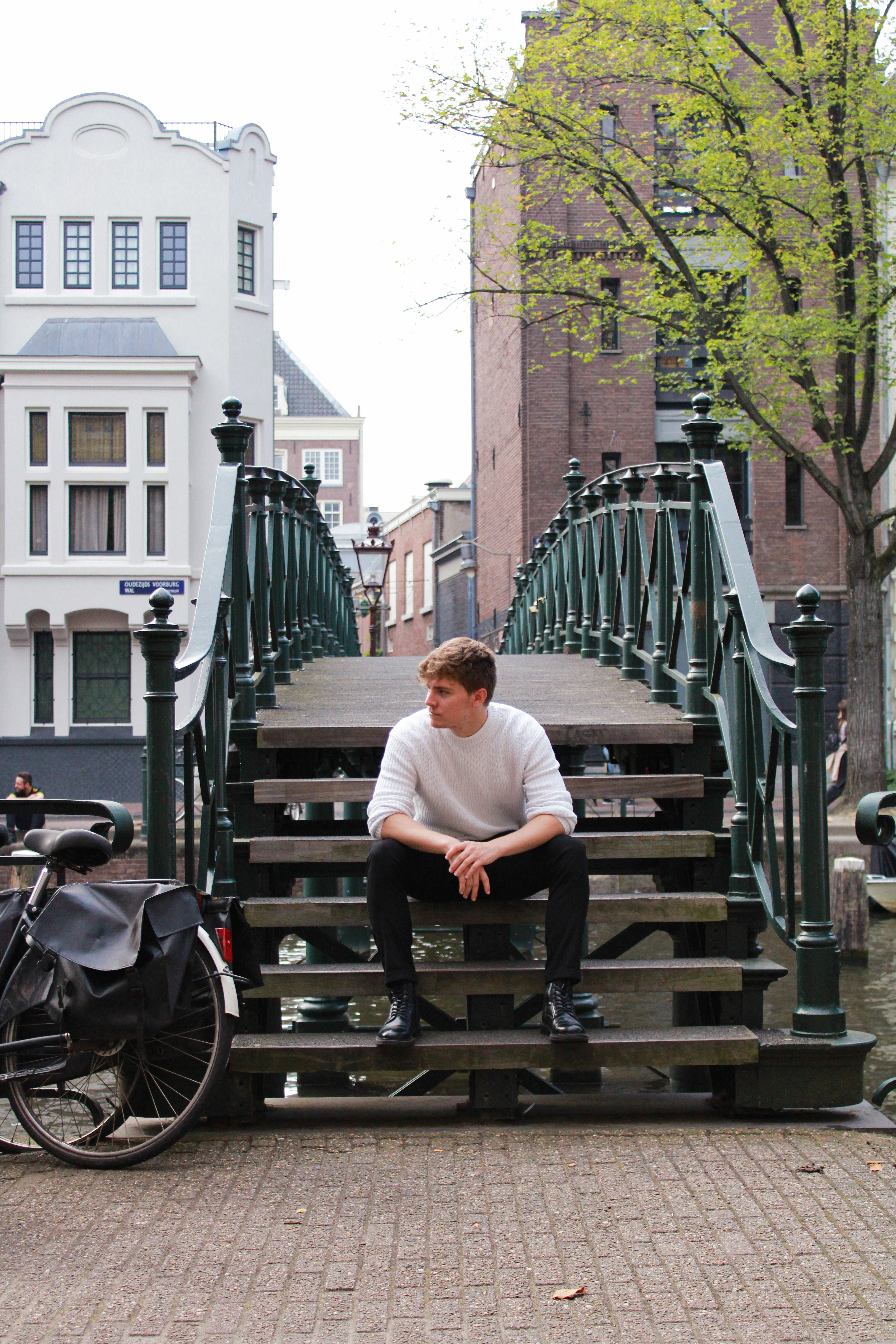 a man sitting on a set of stairs next to a bike