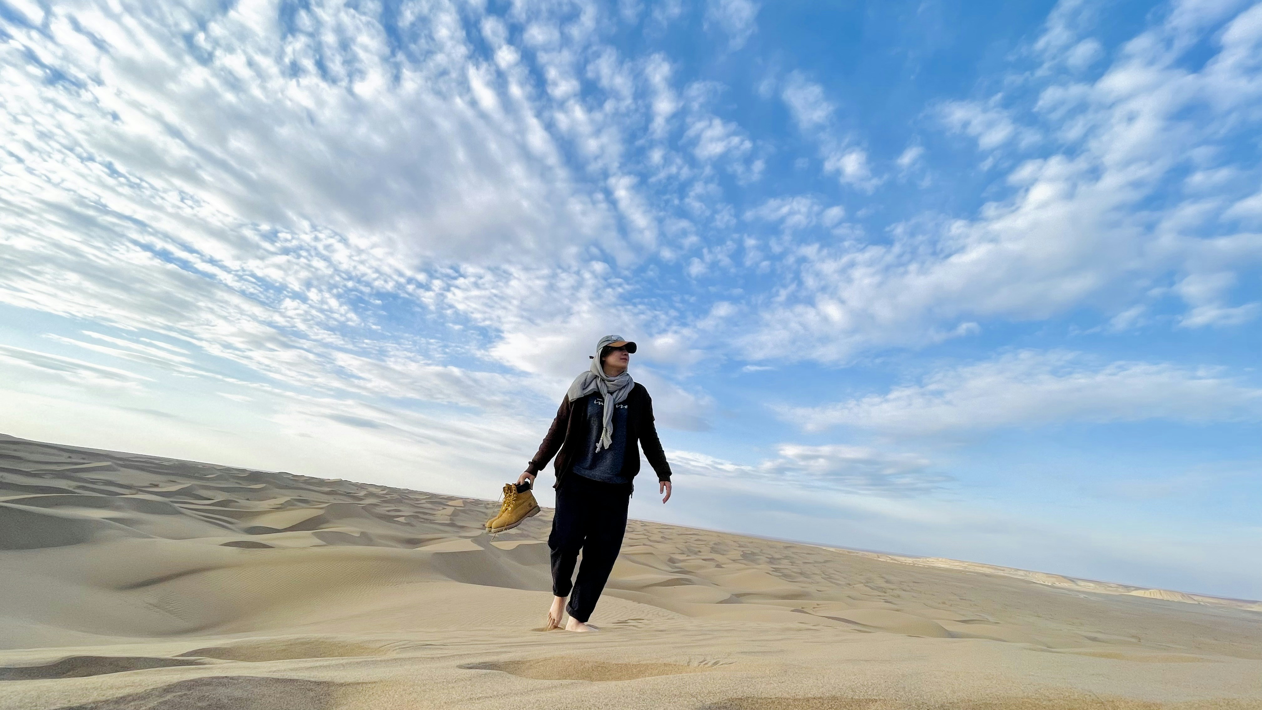 Un homme marchant sur une plage de sable sous un ciel bleu photo ...