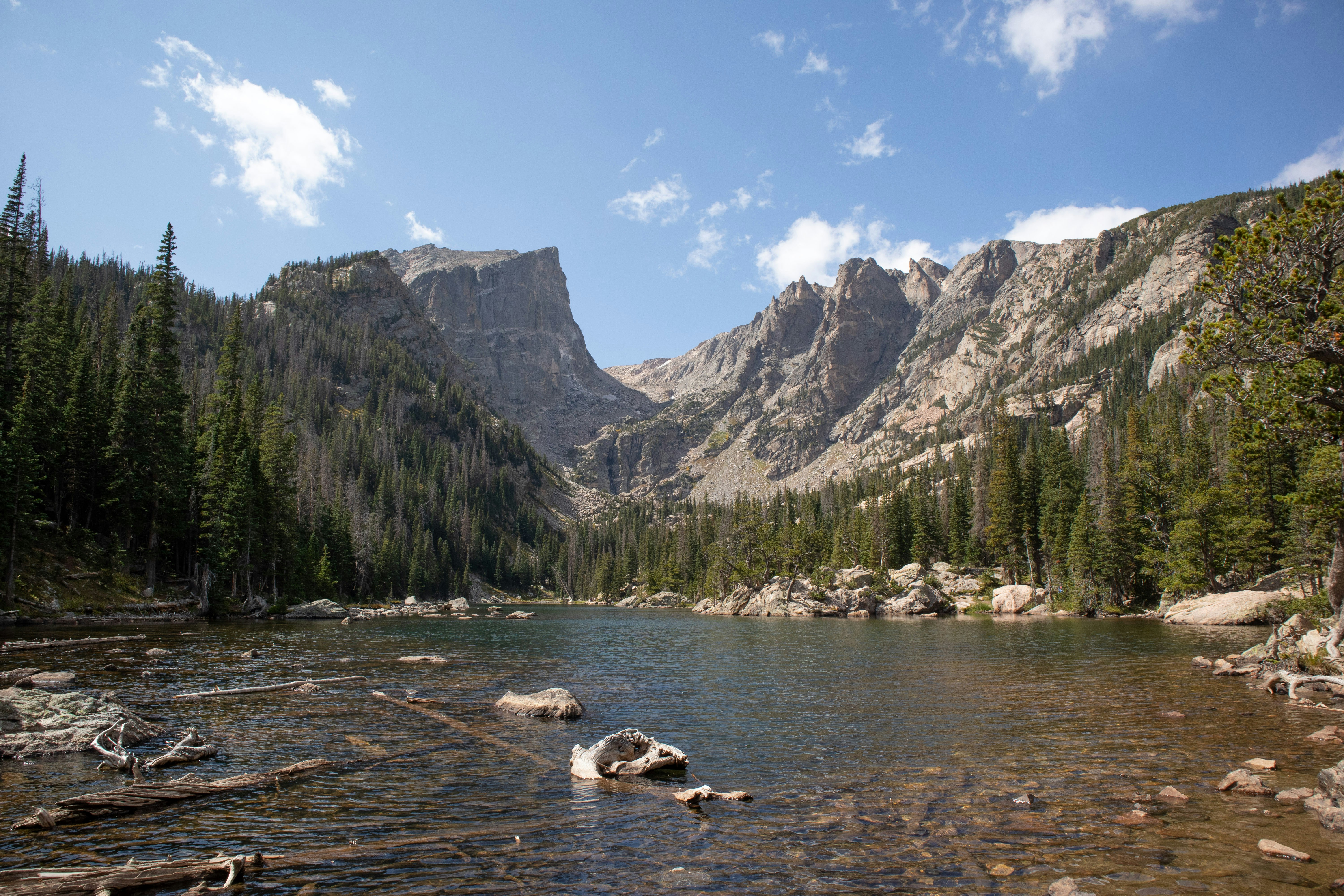 A mountain lake surrounded by trees and rocks photo – Free Land Image ...