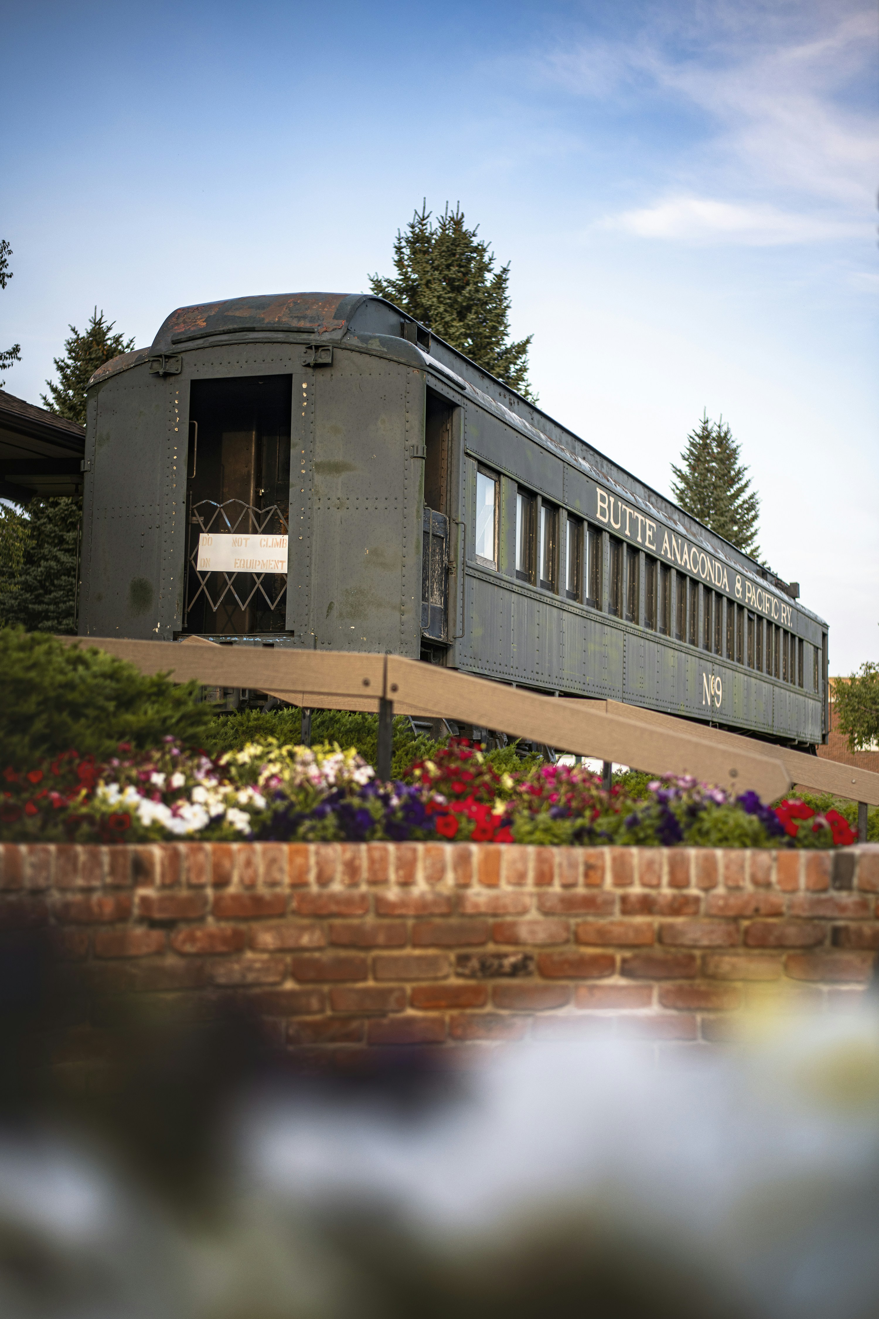 Vintage railcar perched above a bloom-filled brick wall