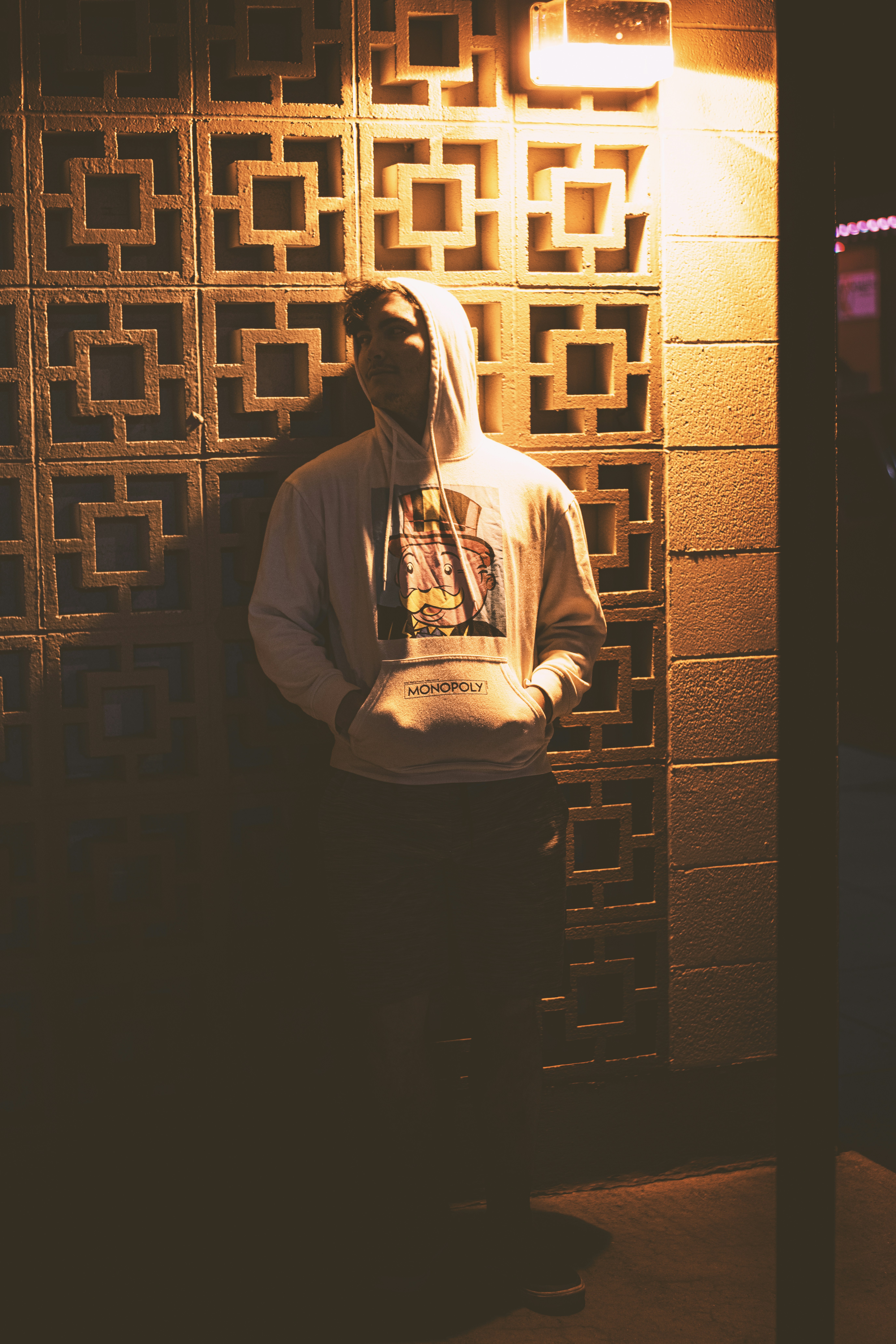 Amber Quiet: A Hooded Figure Amid Geometric Streetlight Grids