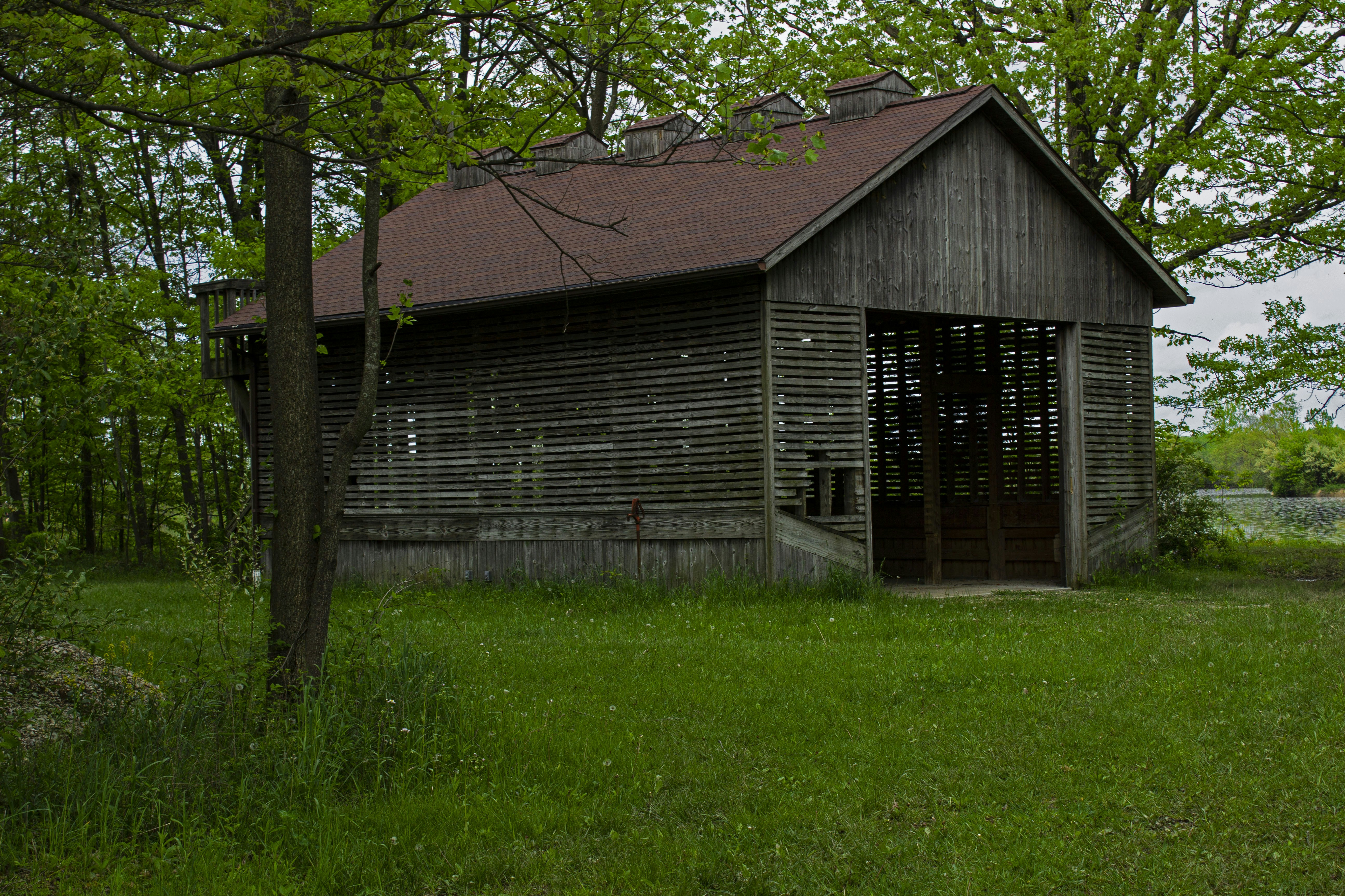 An old wooden building sitting in the middle of a field photo – Free ...