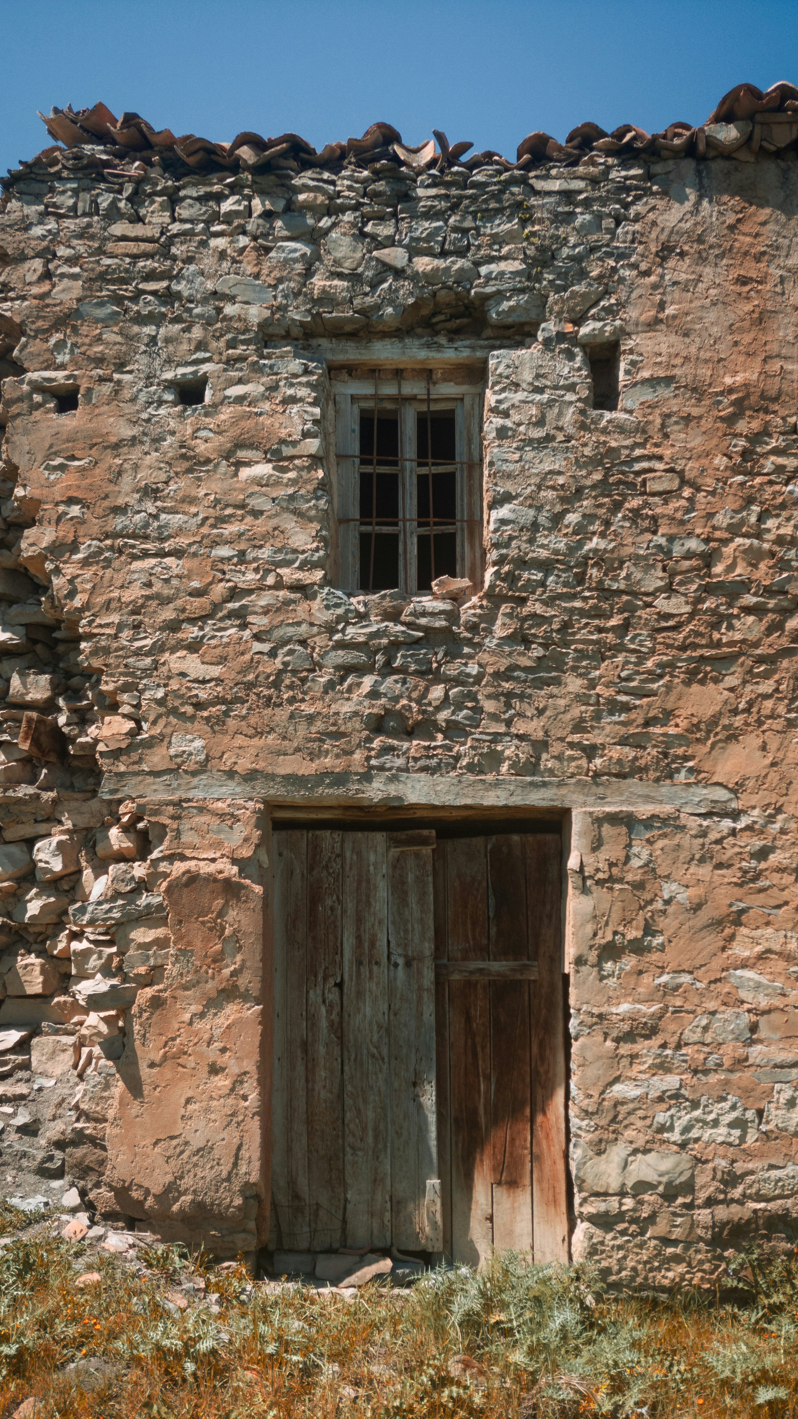 An old house with a wooden door and a broken window