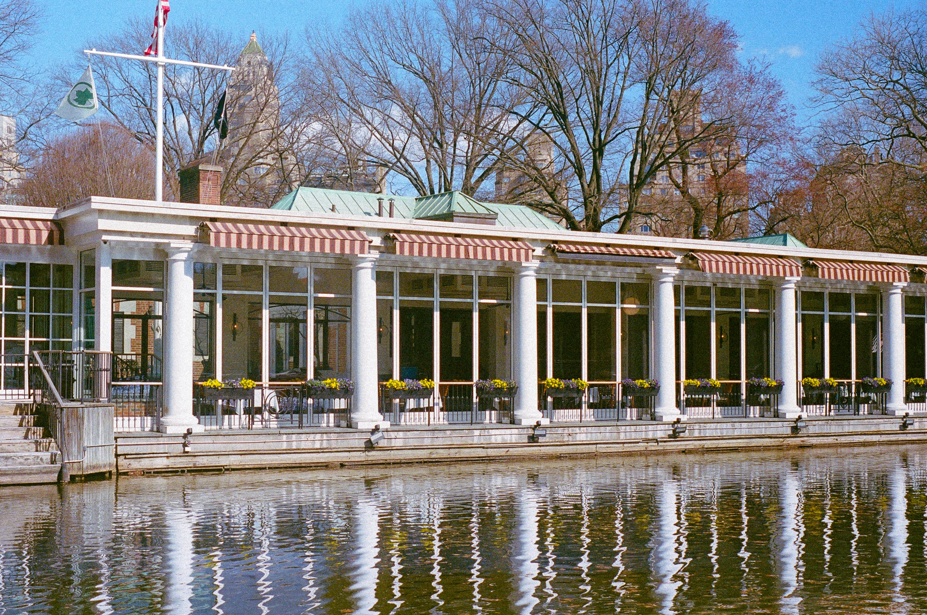 Glasshouse by the Water: Riverside Conservatory with Red-Striped Awnings