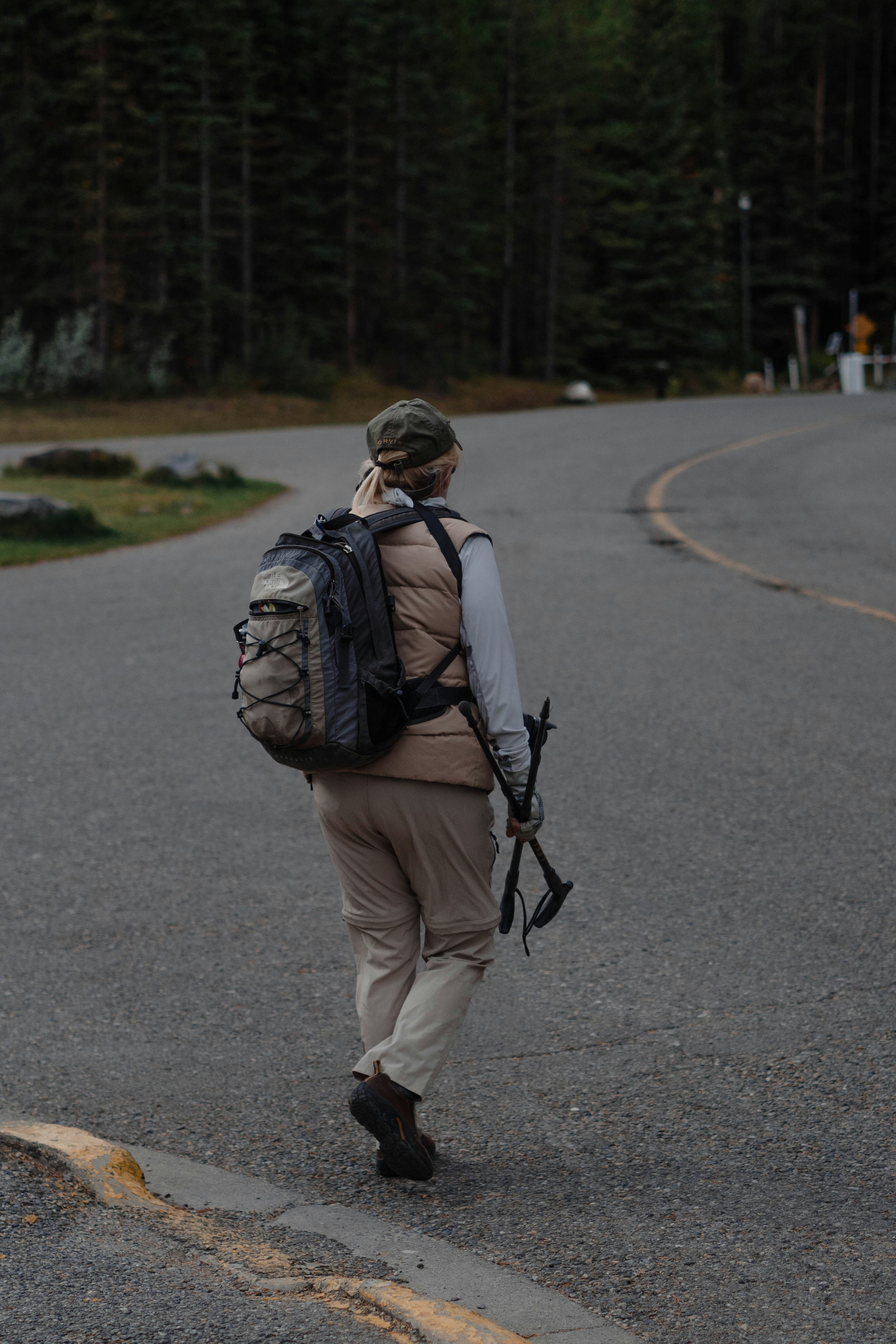a man walking down a road with a backpack on his back