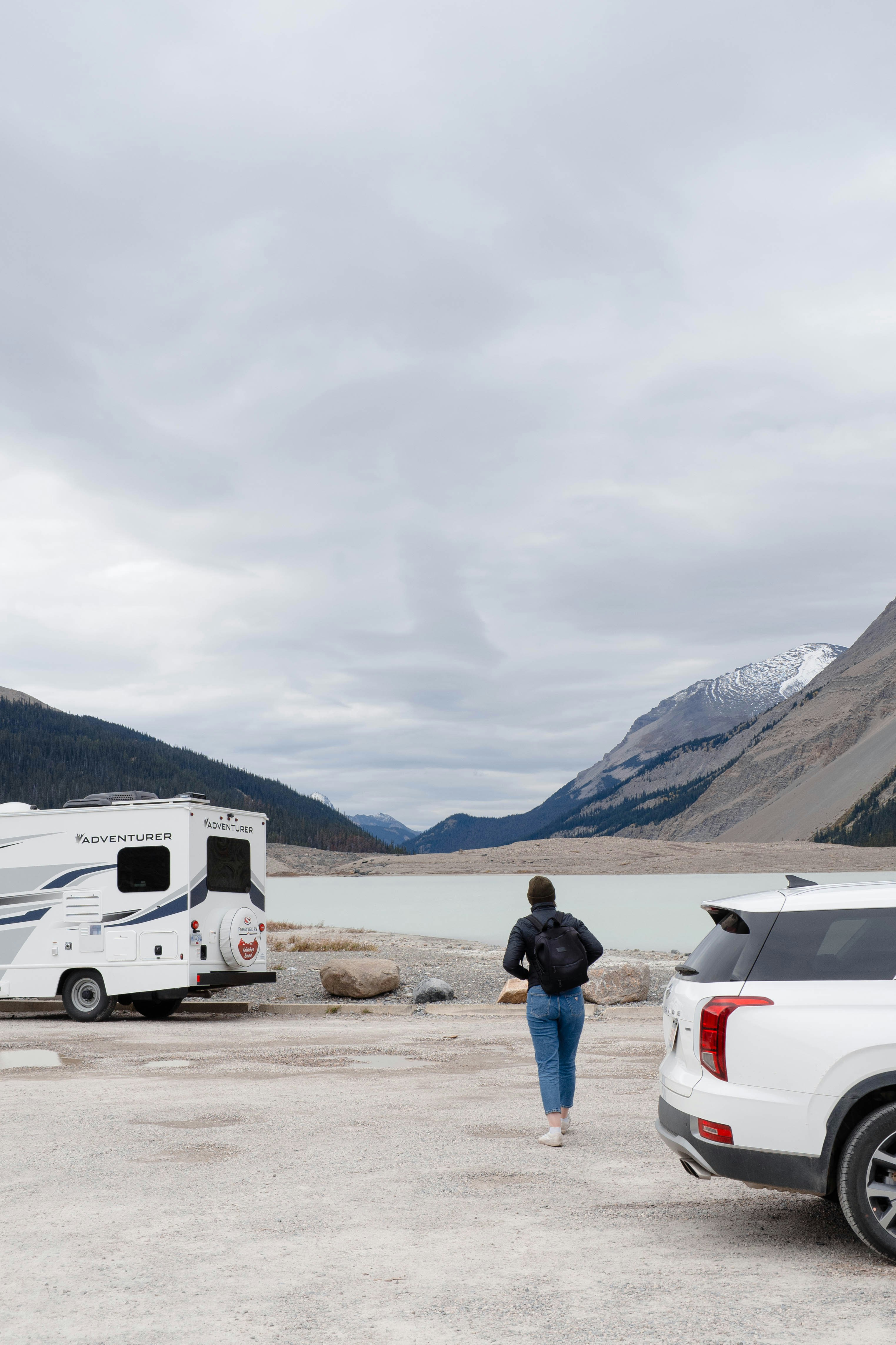 A person walking towards a camper in the mountains photo – Free Car ...