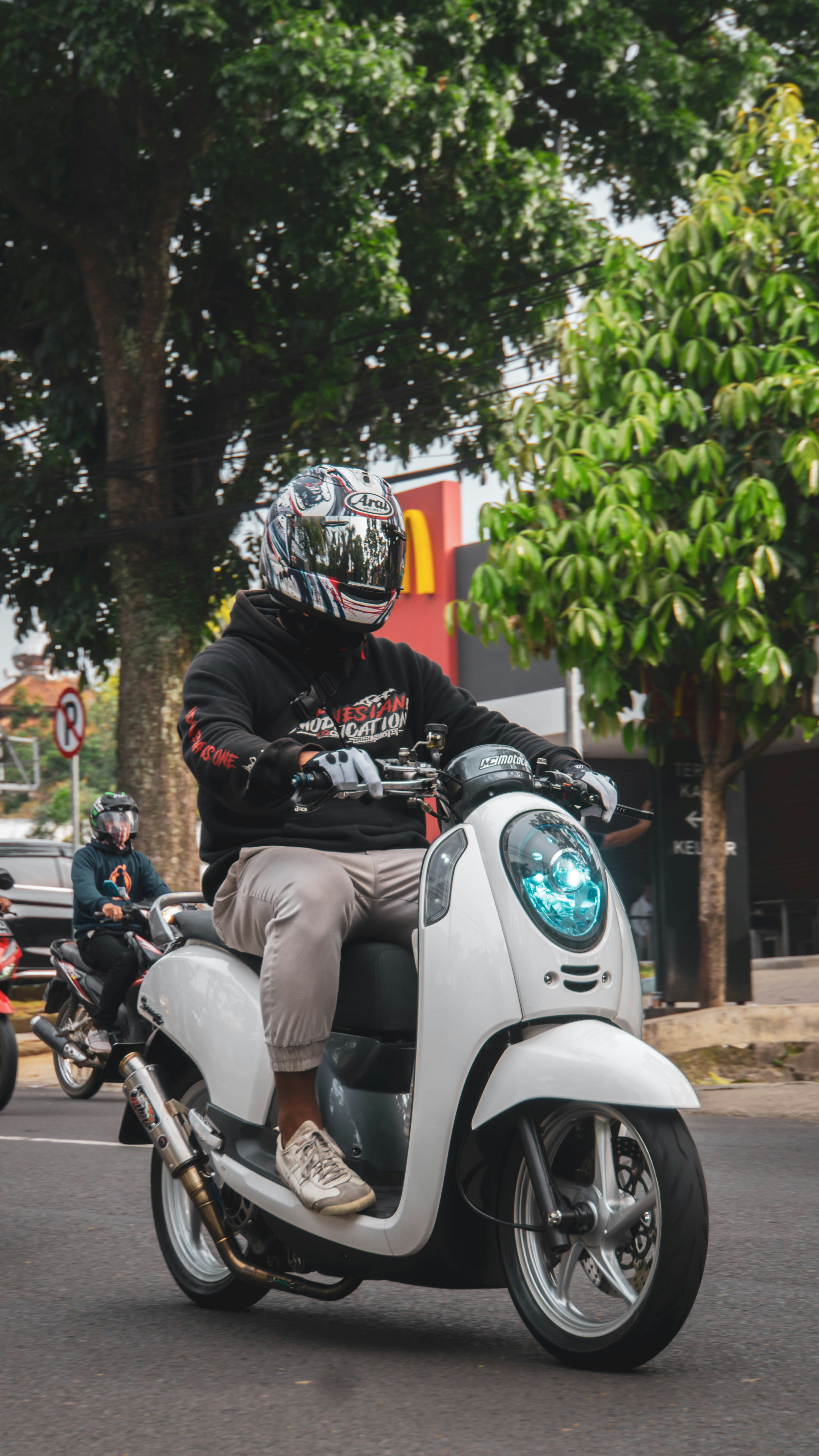 a man riding a motorcycle down a street