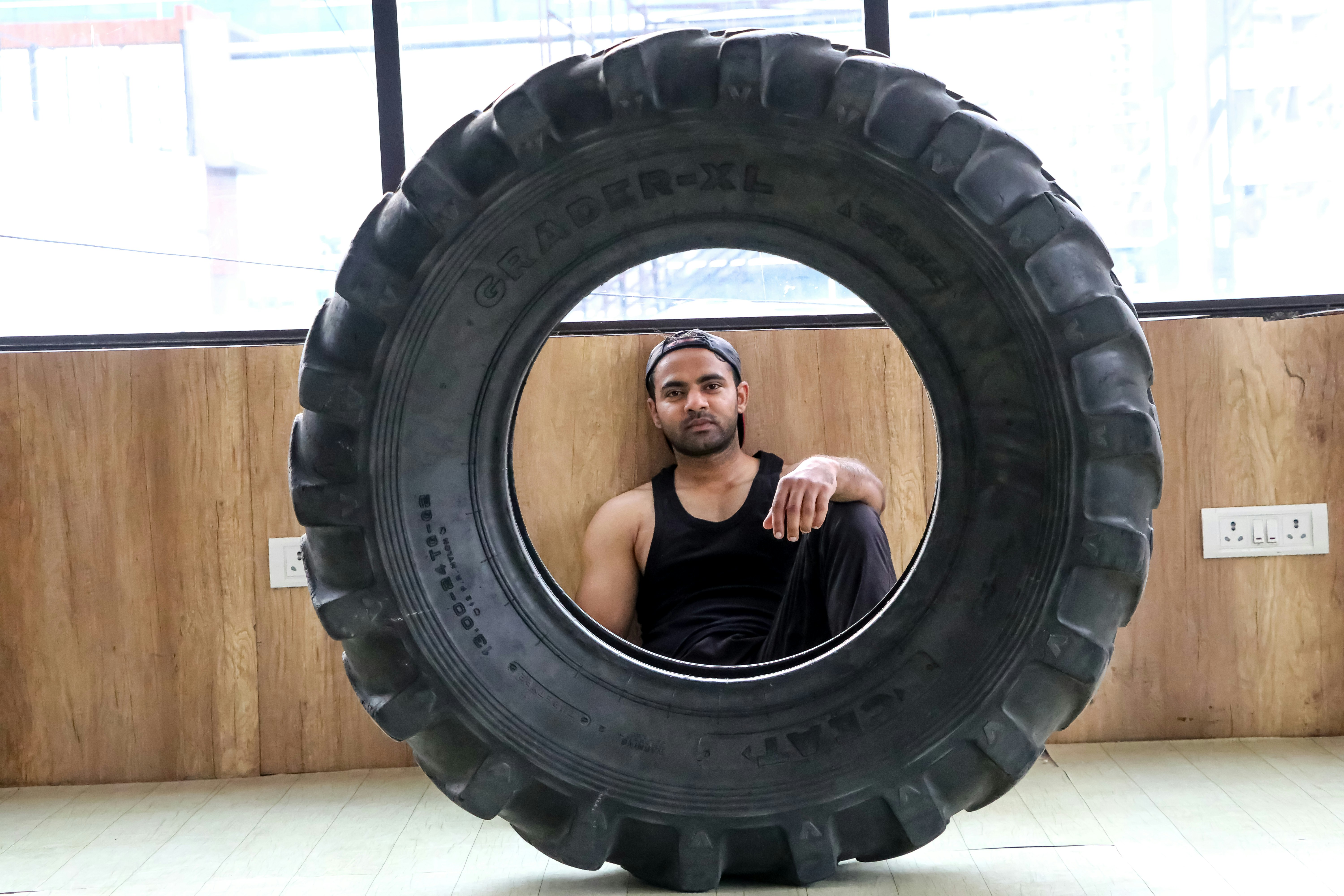 A man sitting inside of a giant tire photo – Free India Image on Unsplash