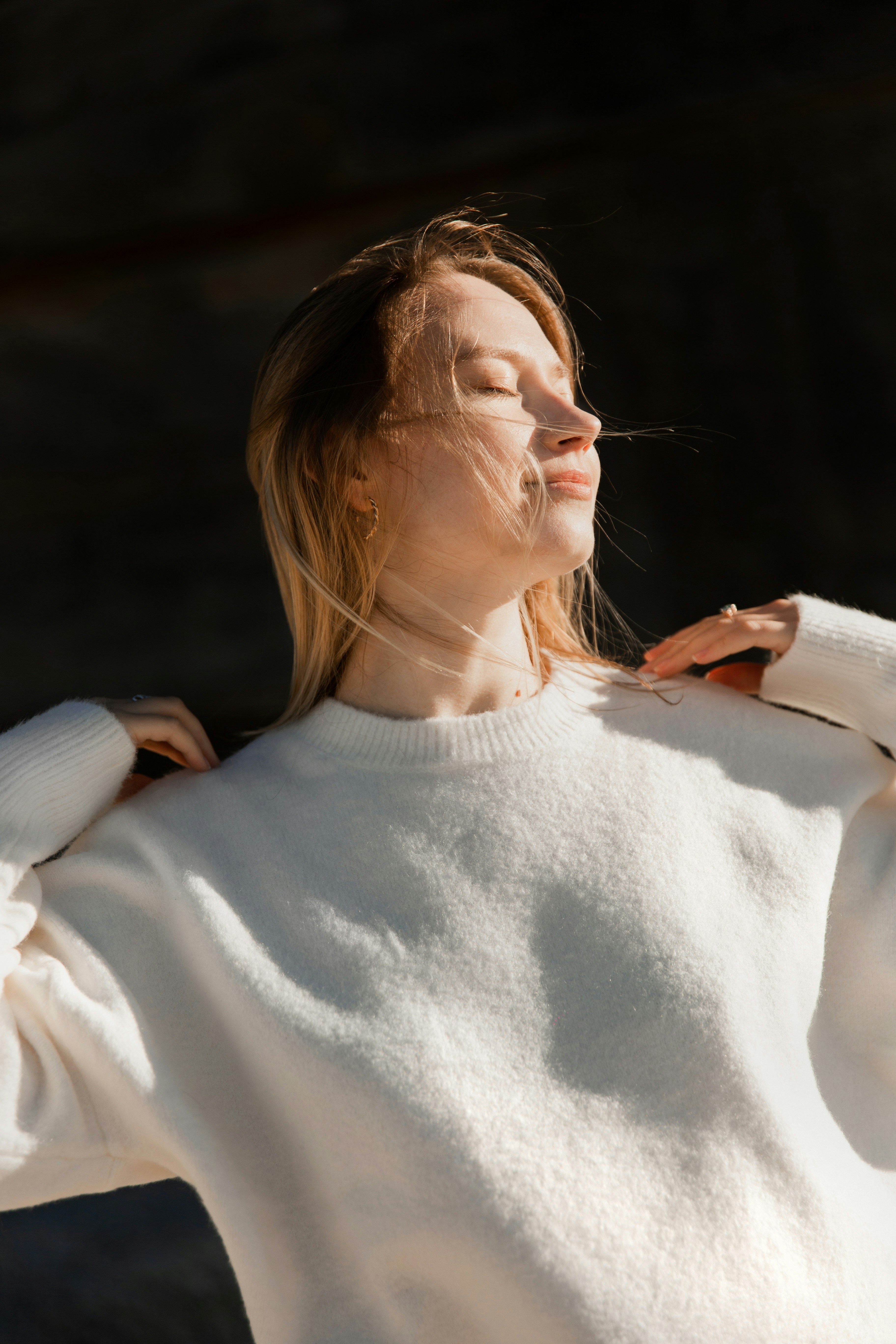 A woman wearing a white sweater and ear buds photo – Free Beach Image ...