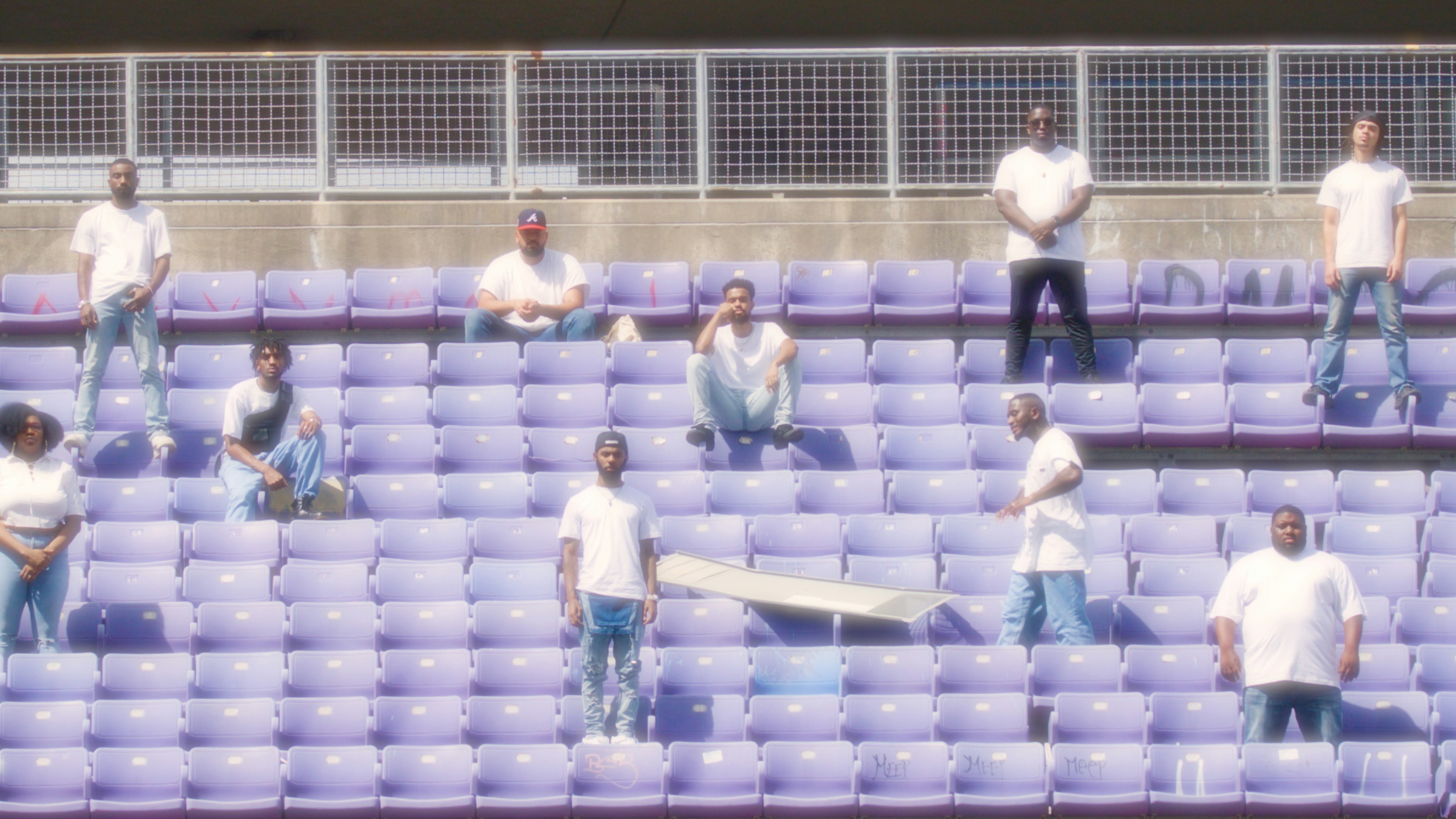 A group of men standing on top of a purple bleachers photo – Free Human ...