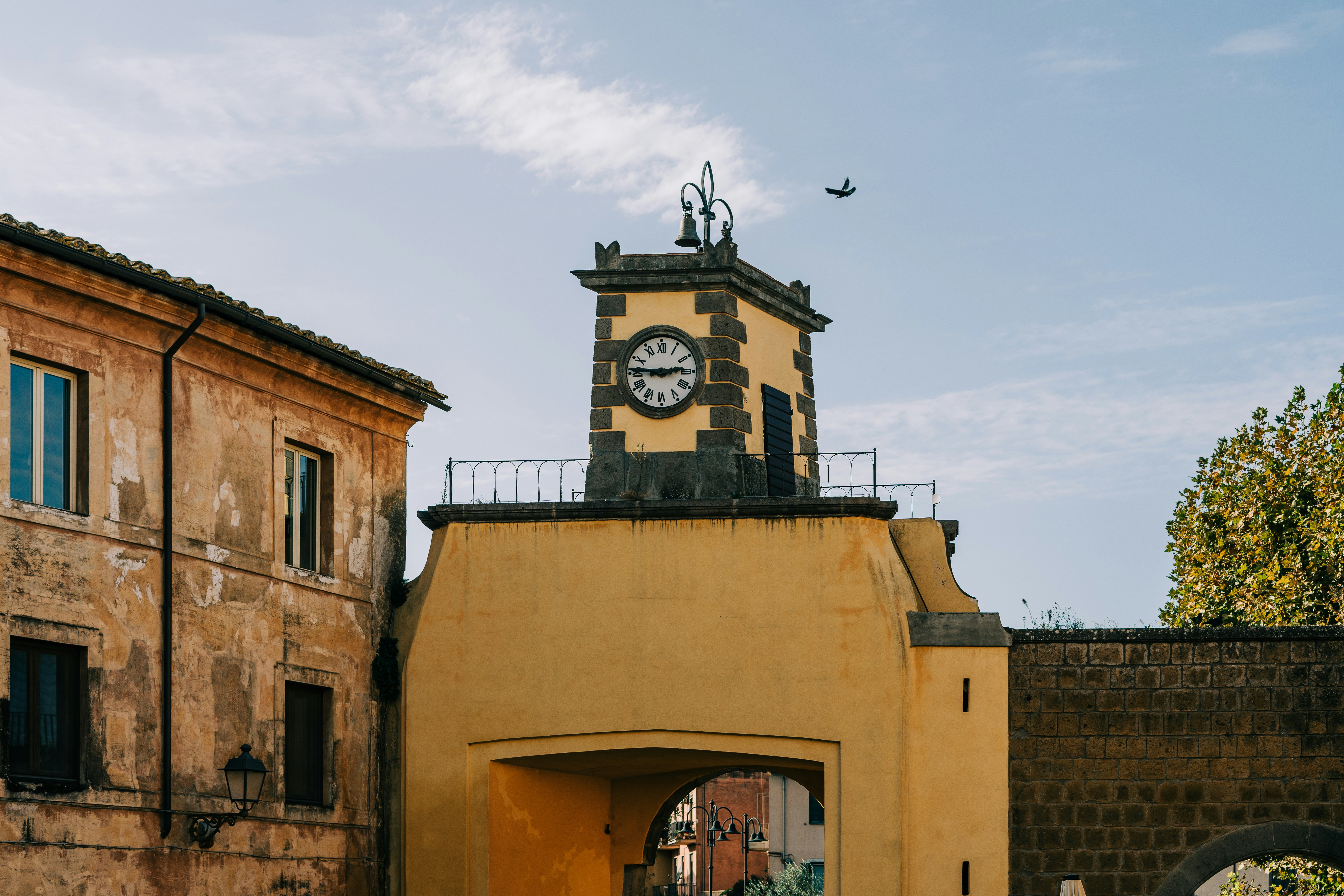 The Time Gate: Sunlit Arch Framed by a Weathered Clock Tower
