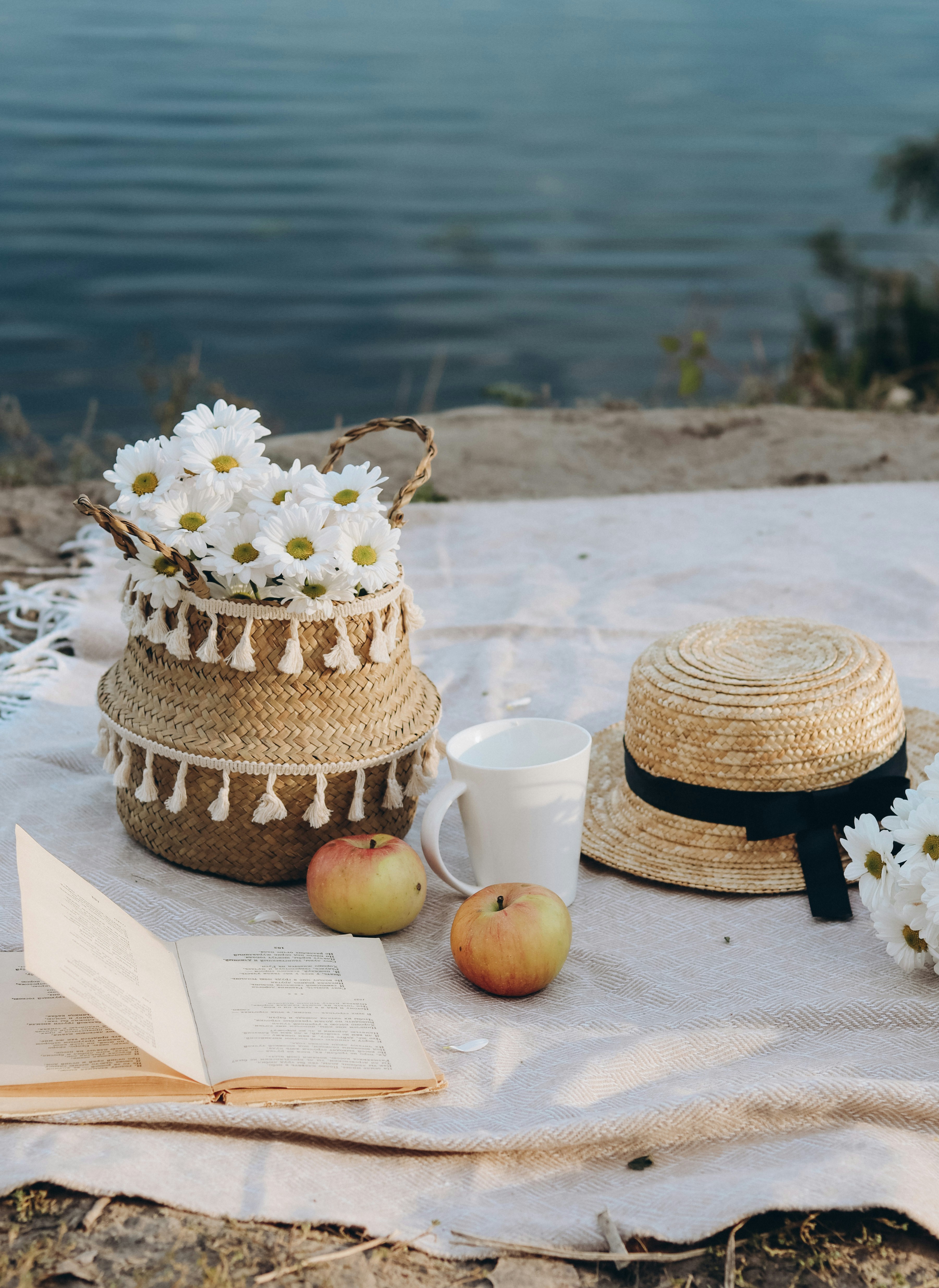 a table topped with a basket of flowers next to a cup of coffee