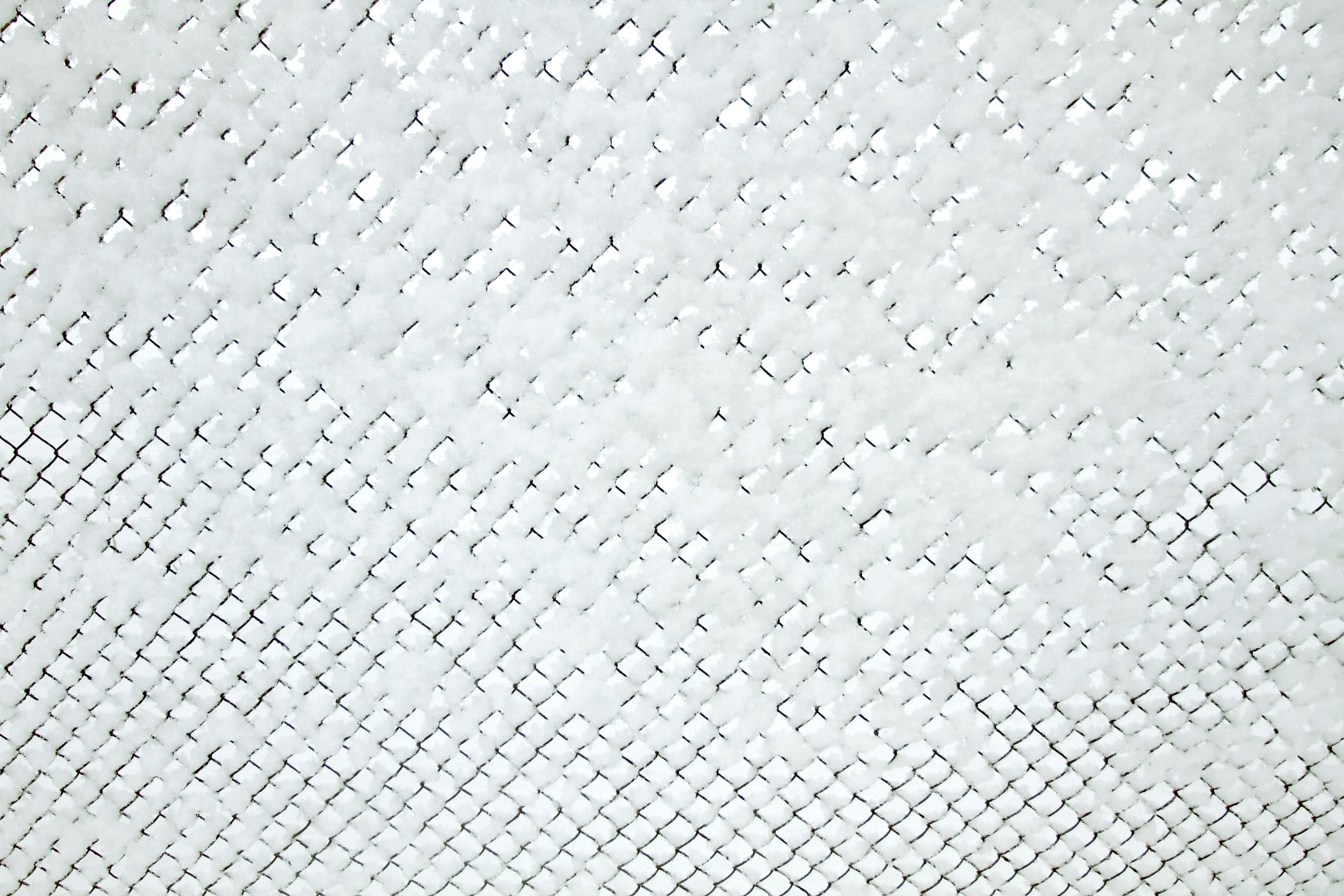 A close-up view of a textured surface composed of interlocking white tiles, creating a visually striking pattern. The uniformity and simplicity evoke a sense of calm.