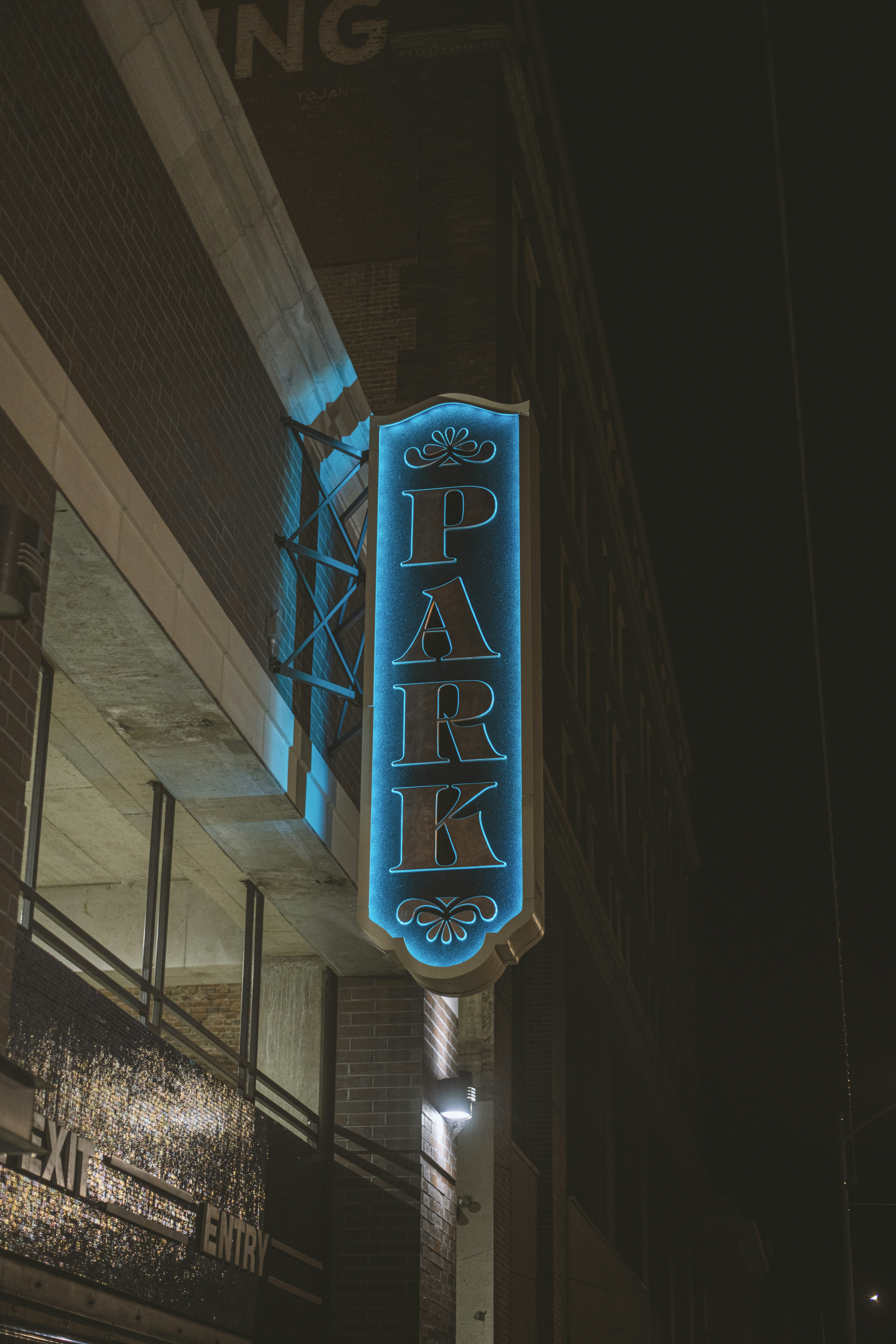 A neon sign that reads park on the side of a building photo – Free ...