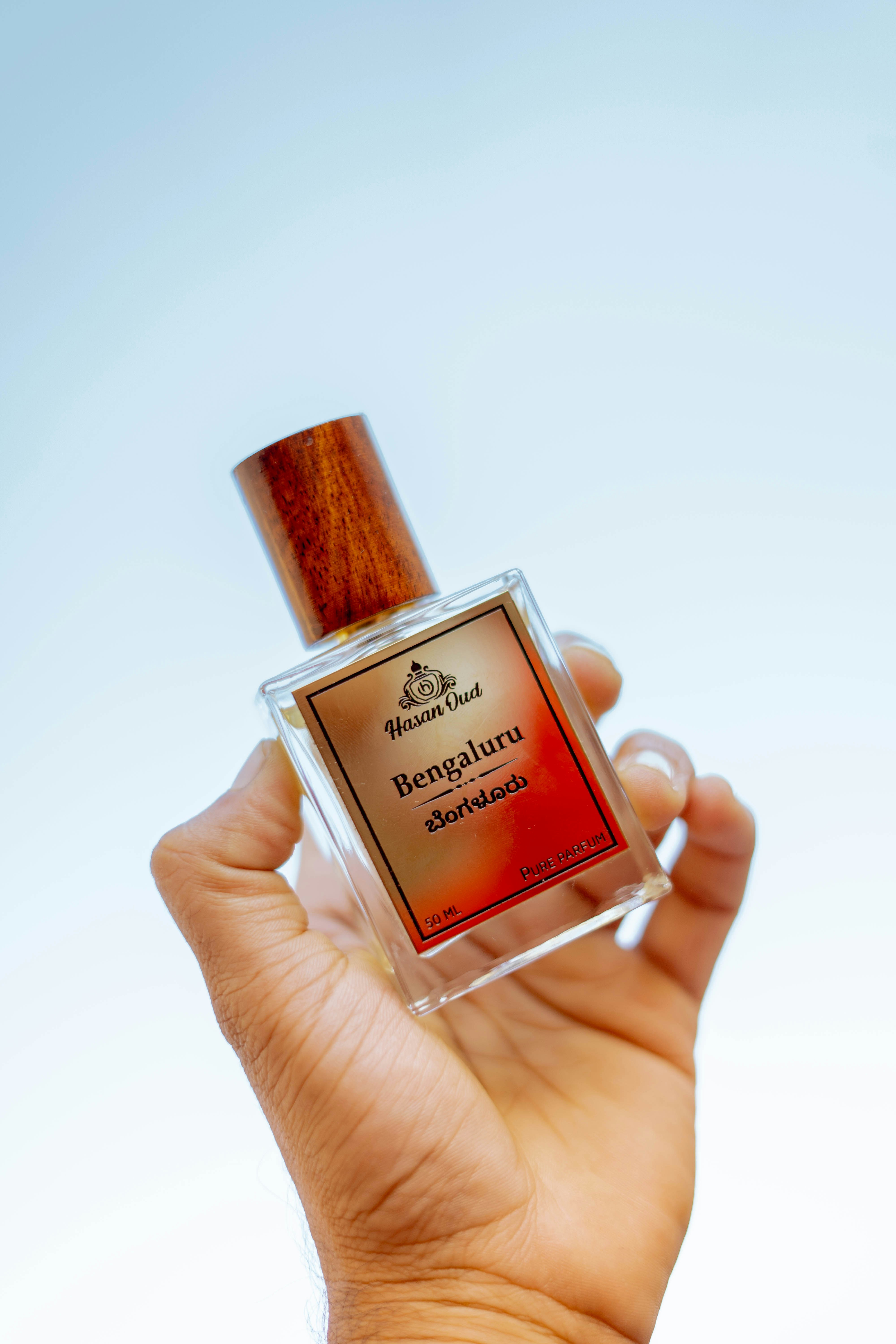 Hasan oud perfume  | a person holding a bottle of perfume in their hand