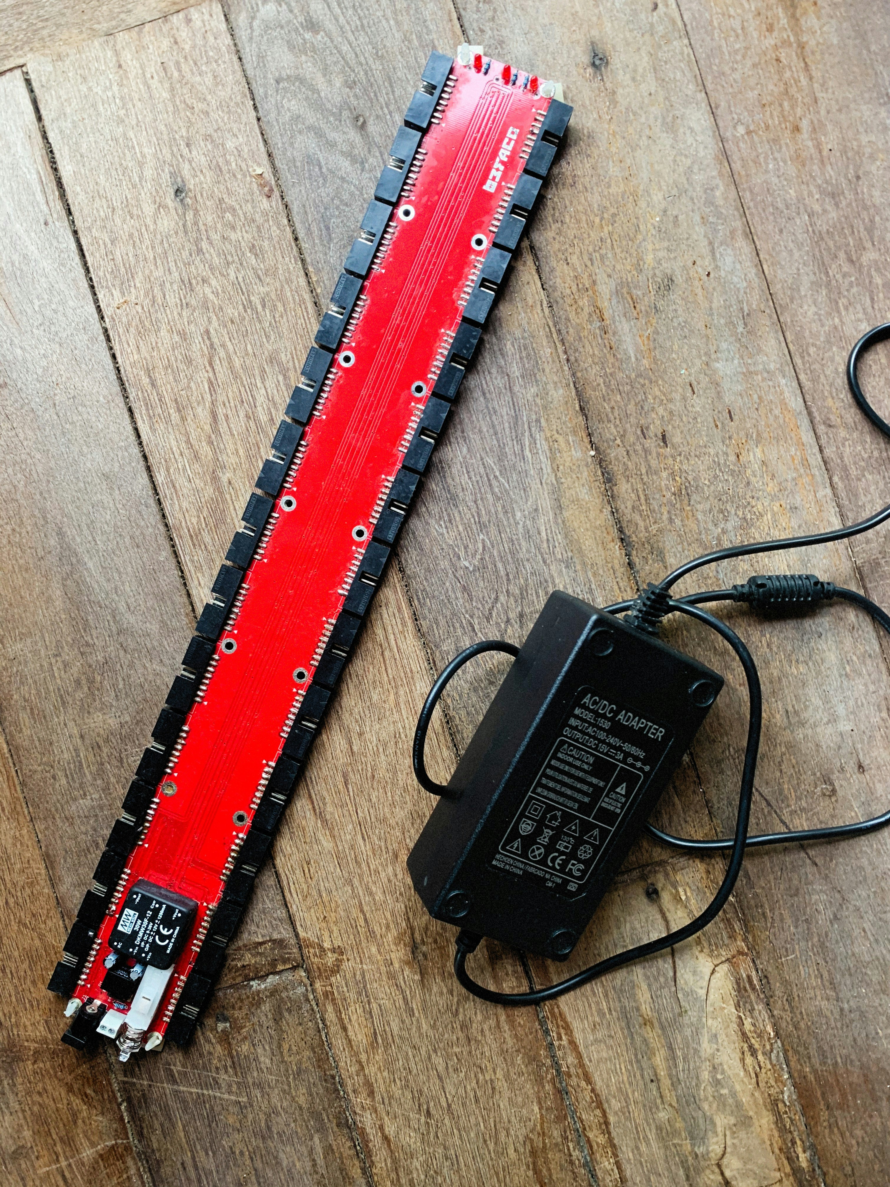 A cordless saw is laying on the floor next to a charger photo – Free ...