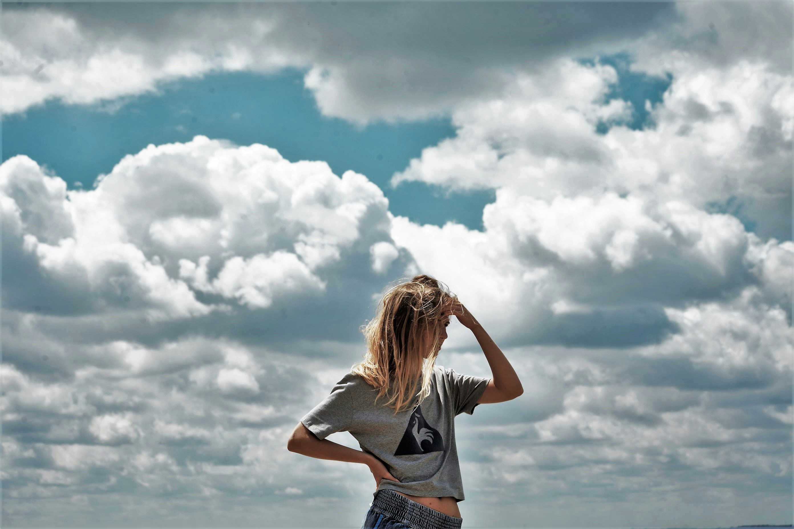 Sunlit Silhouette: A Breeze-Tossed Moment Under Open Sky