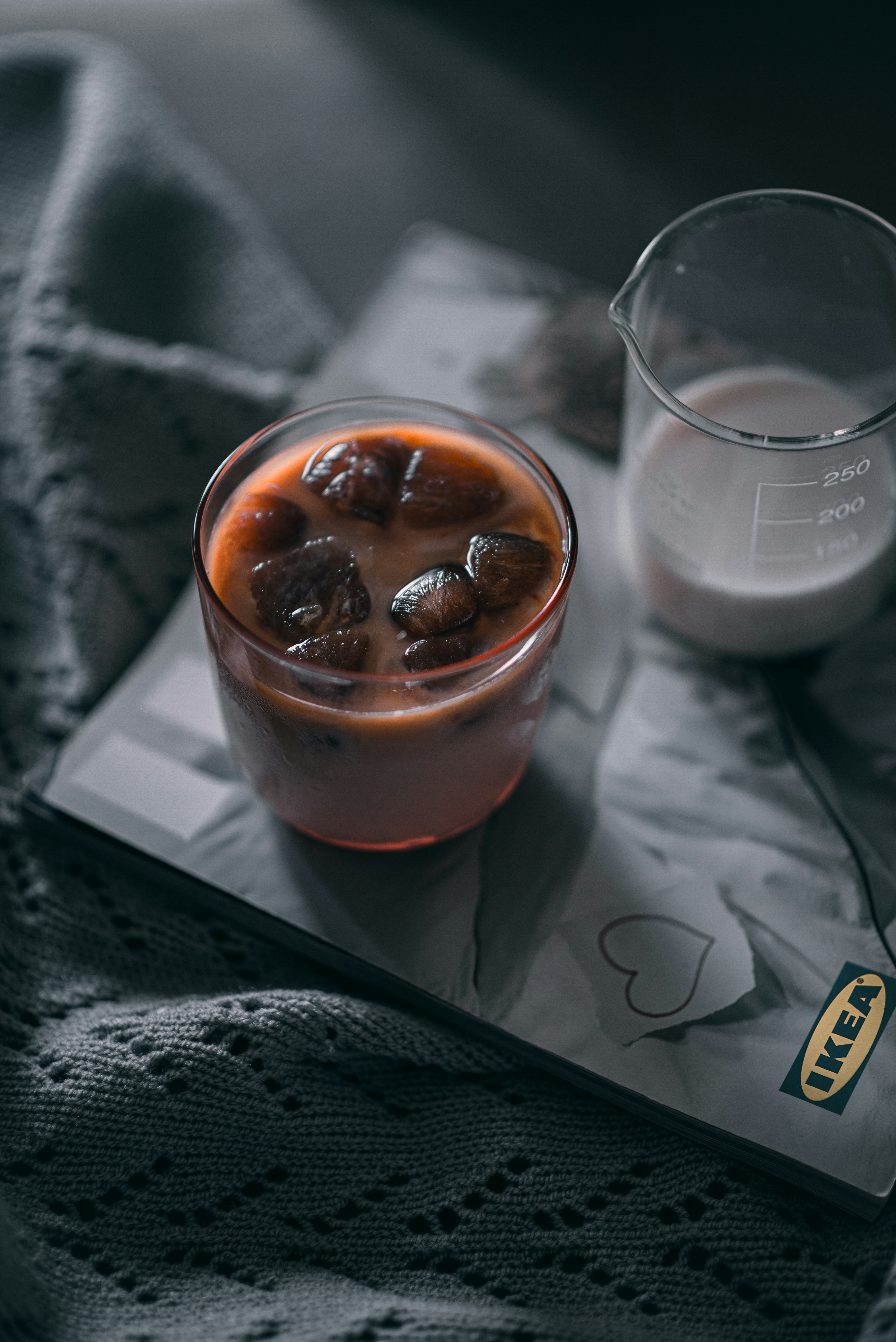 a drink in a glass next to a glass of milk