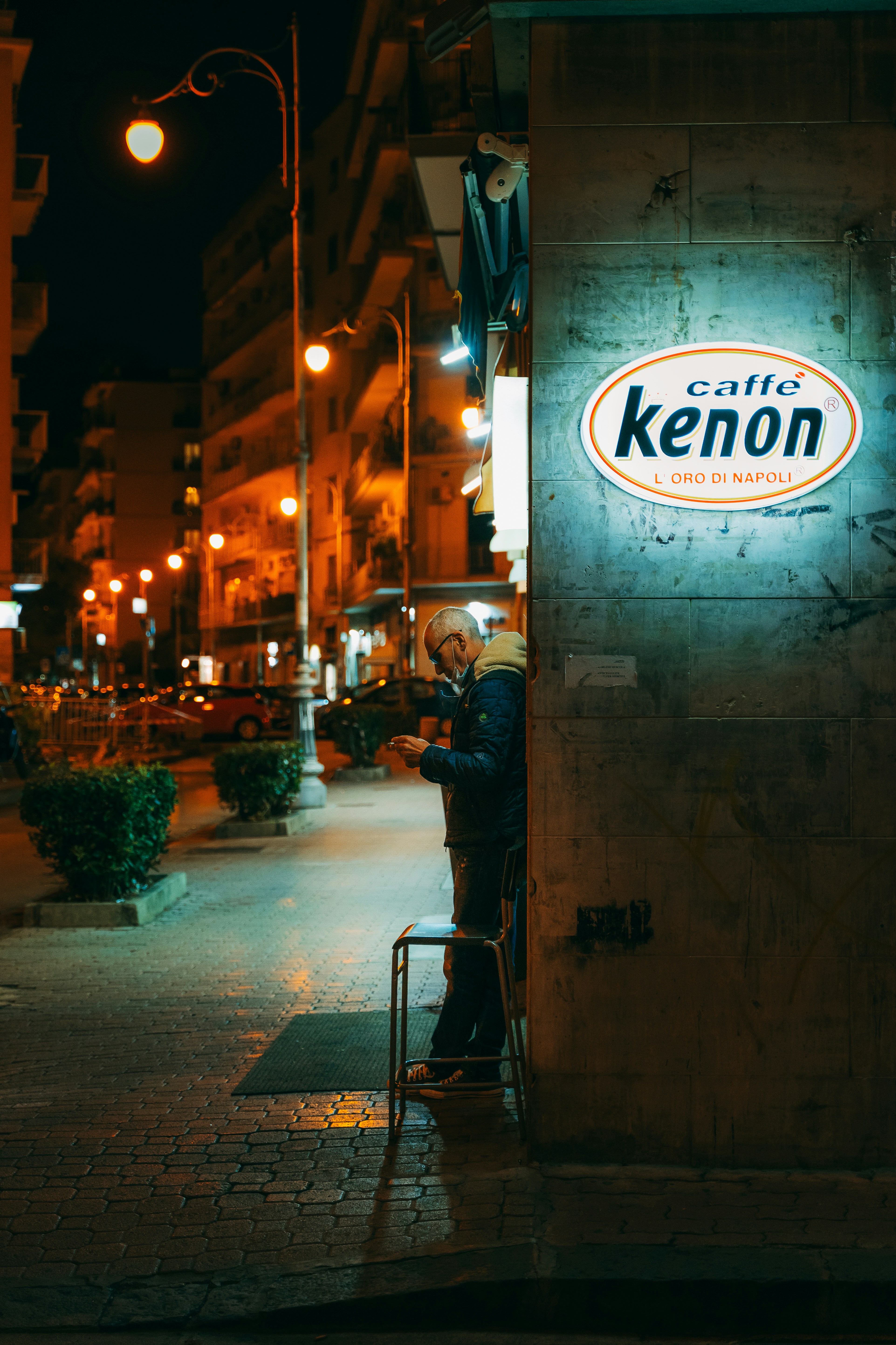 A man standing next to a sign on the side of a building photo – Free ...
