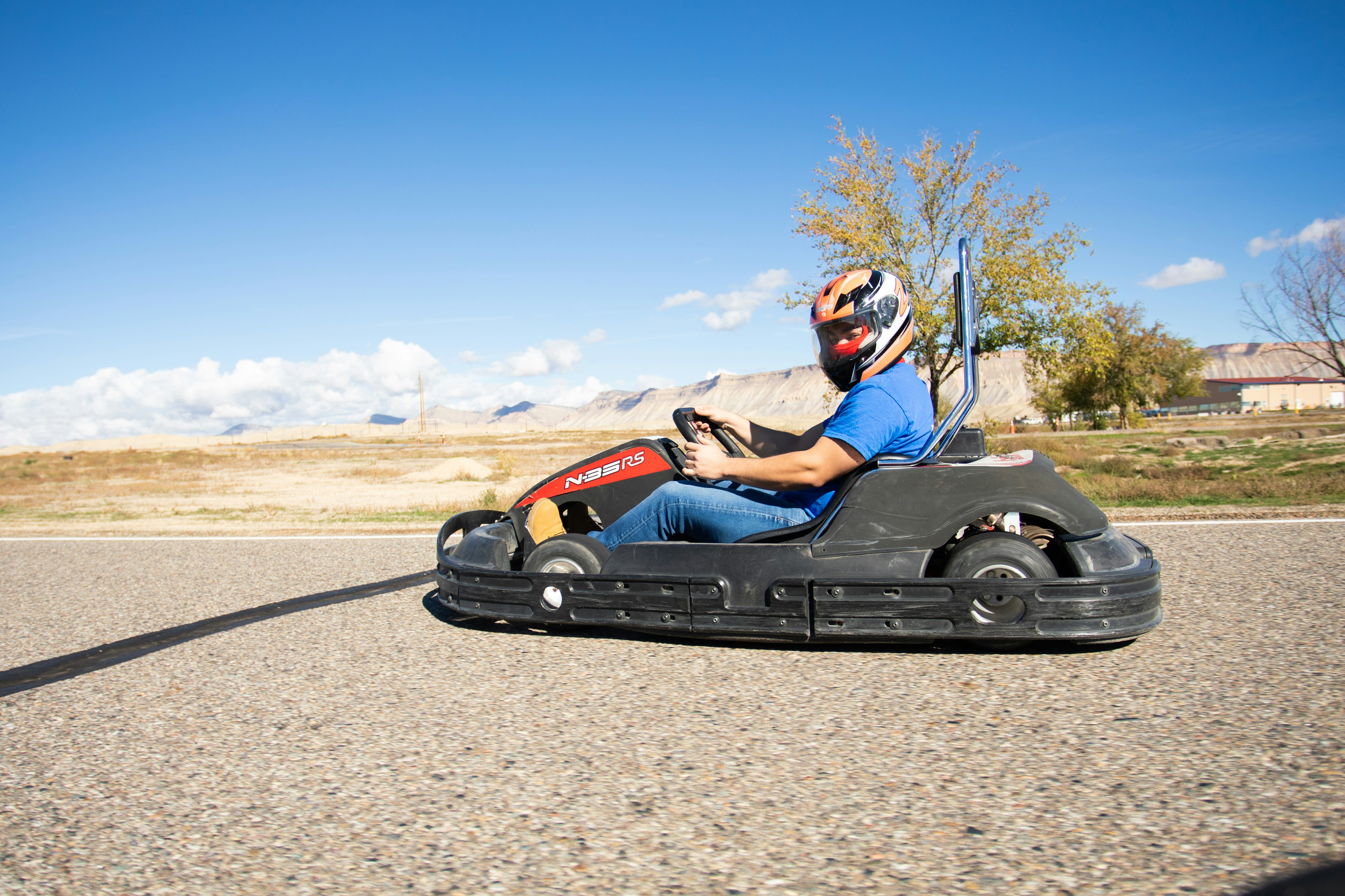 A man riding a go - kart down a road photo – Free Human Image on Unsplash