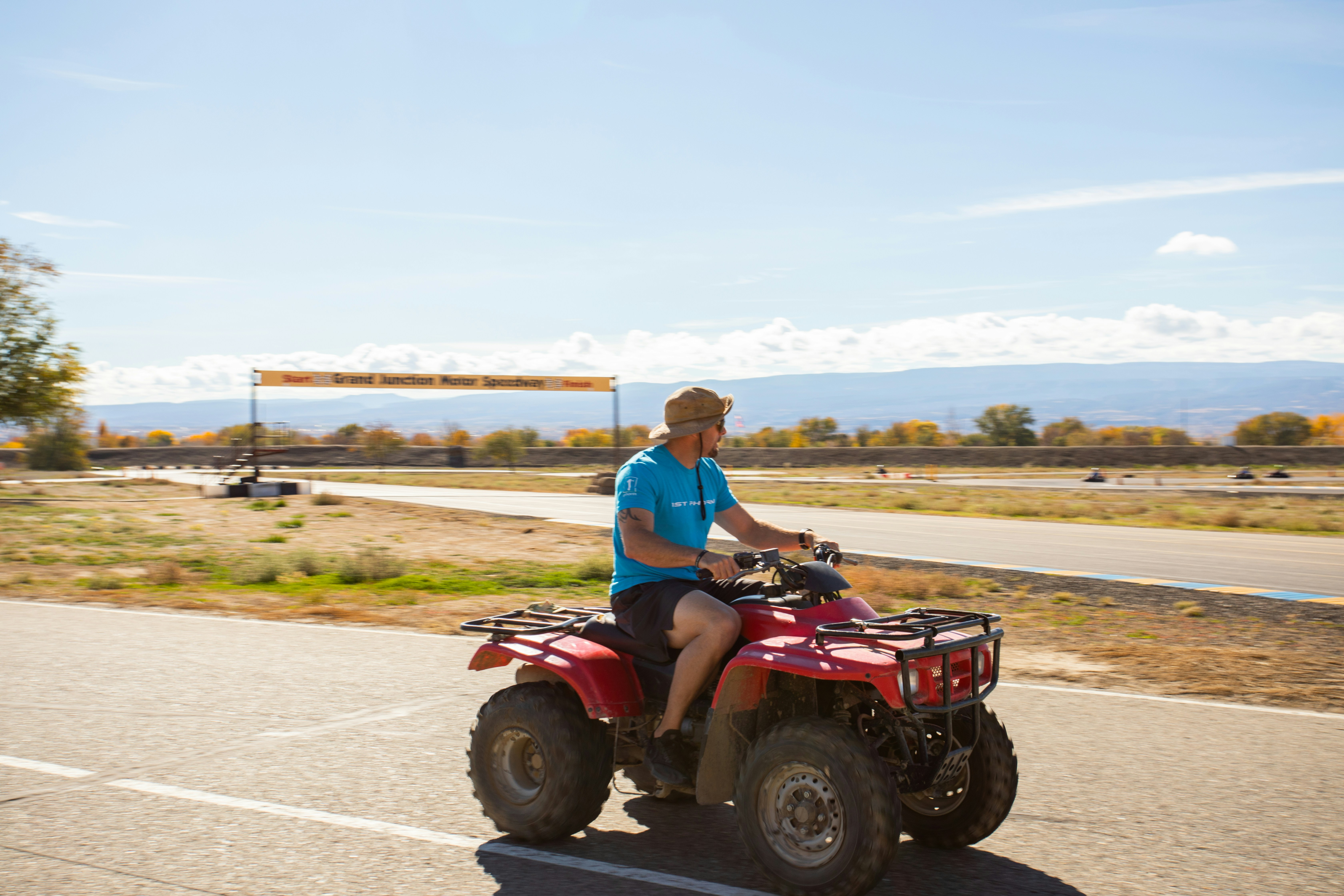 A man riding on the back of a red four wheeler photo – Free Person ...