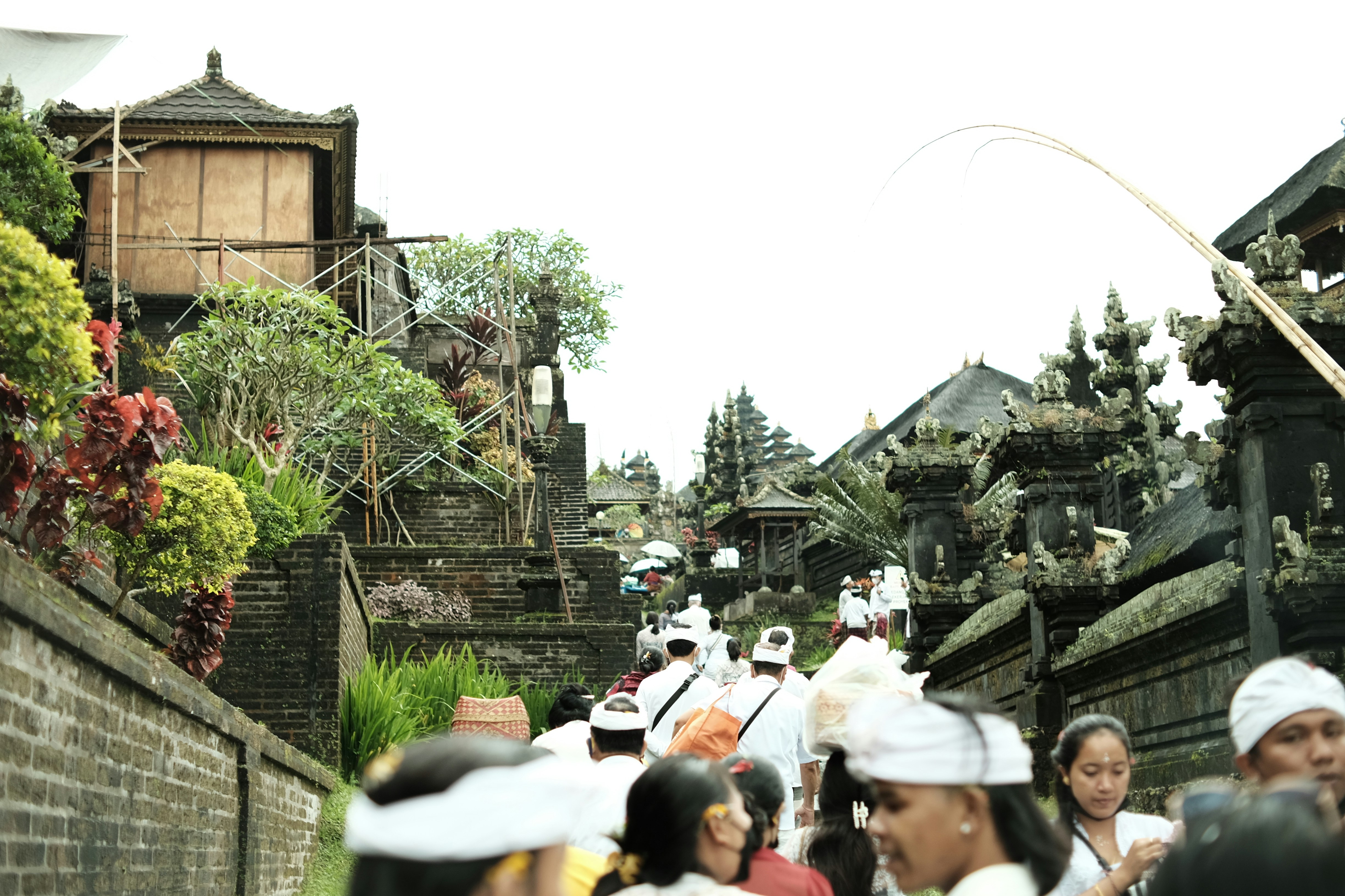 Headbanded Pilgrims Thread Through an Ancient Balinese Temple Corridor