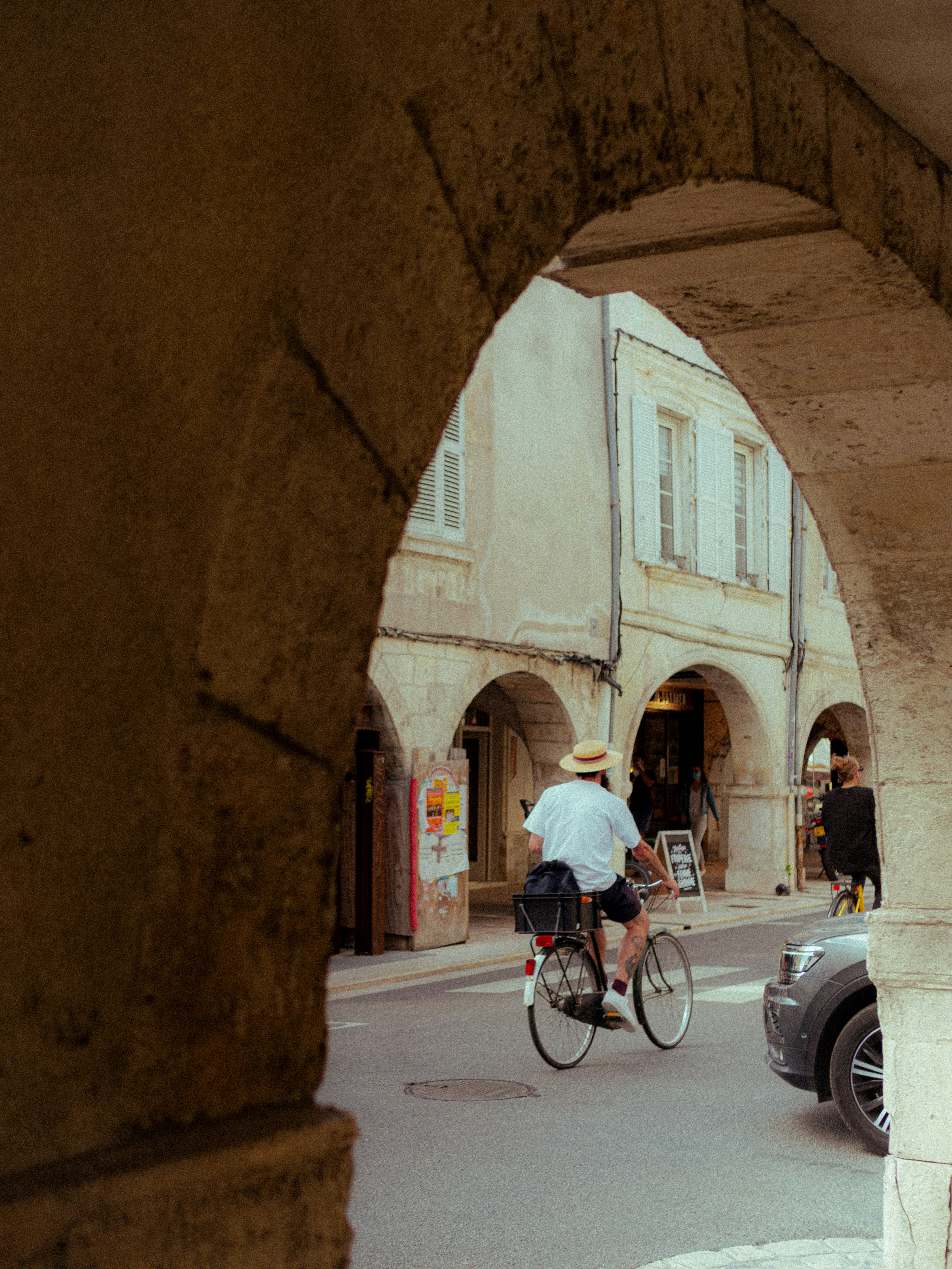 a man riding a bike down a street next to a car
