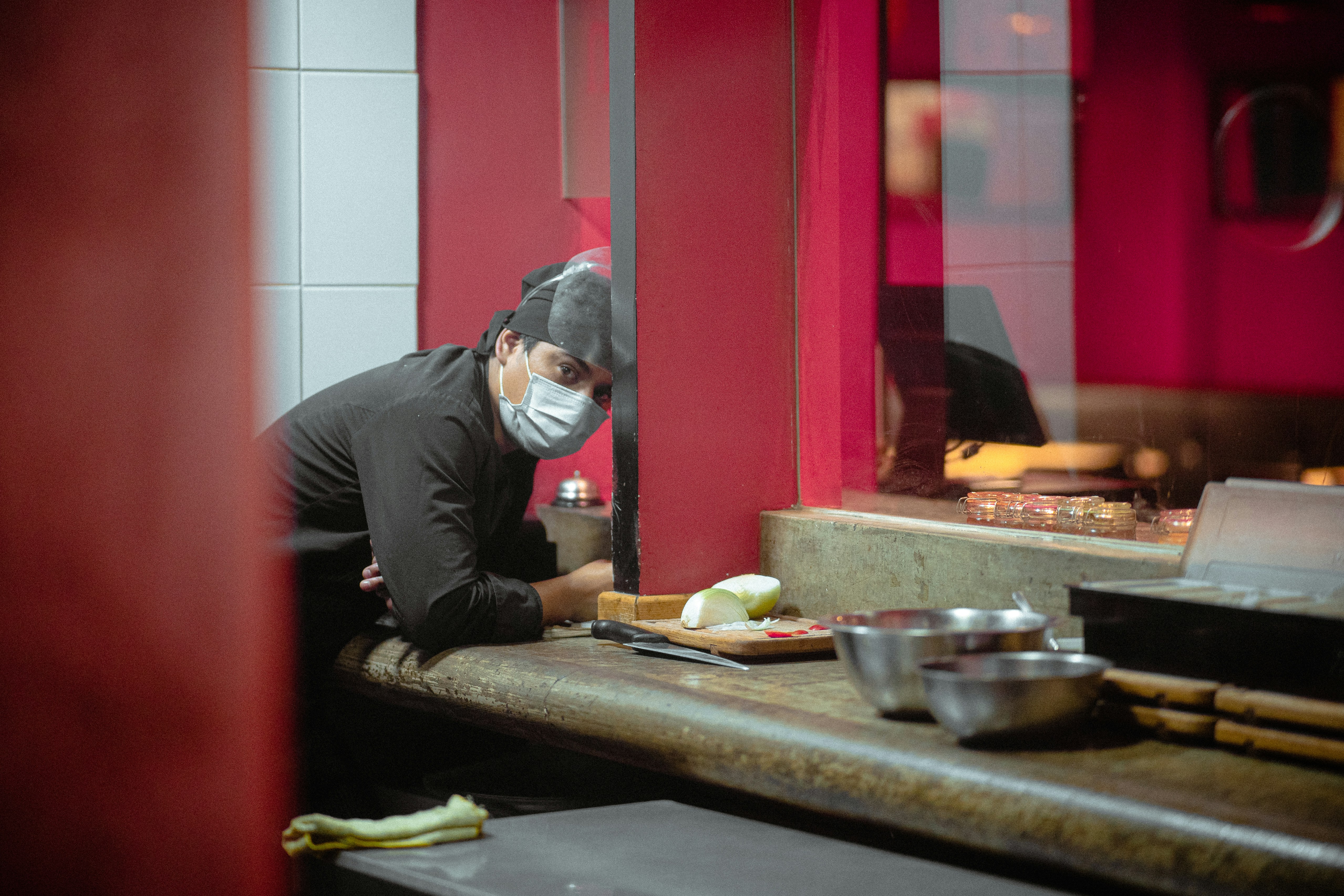 Mask-clad chef at the grill: a quiet moment in the kitchen line