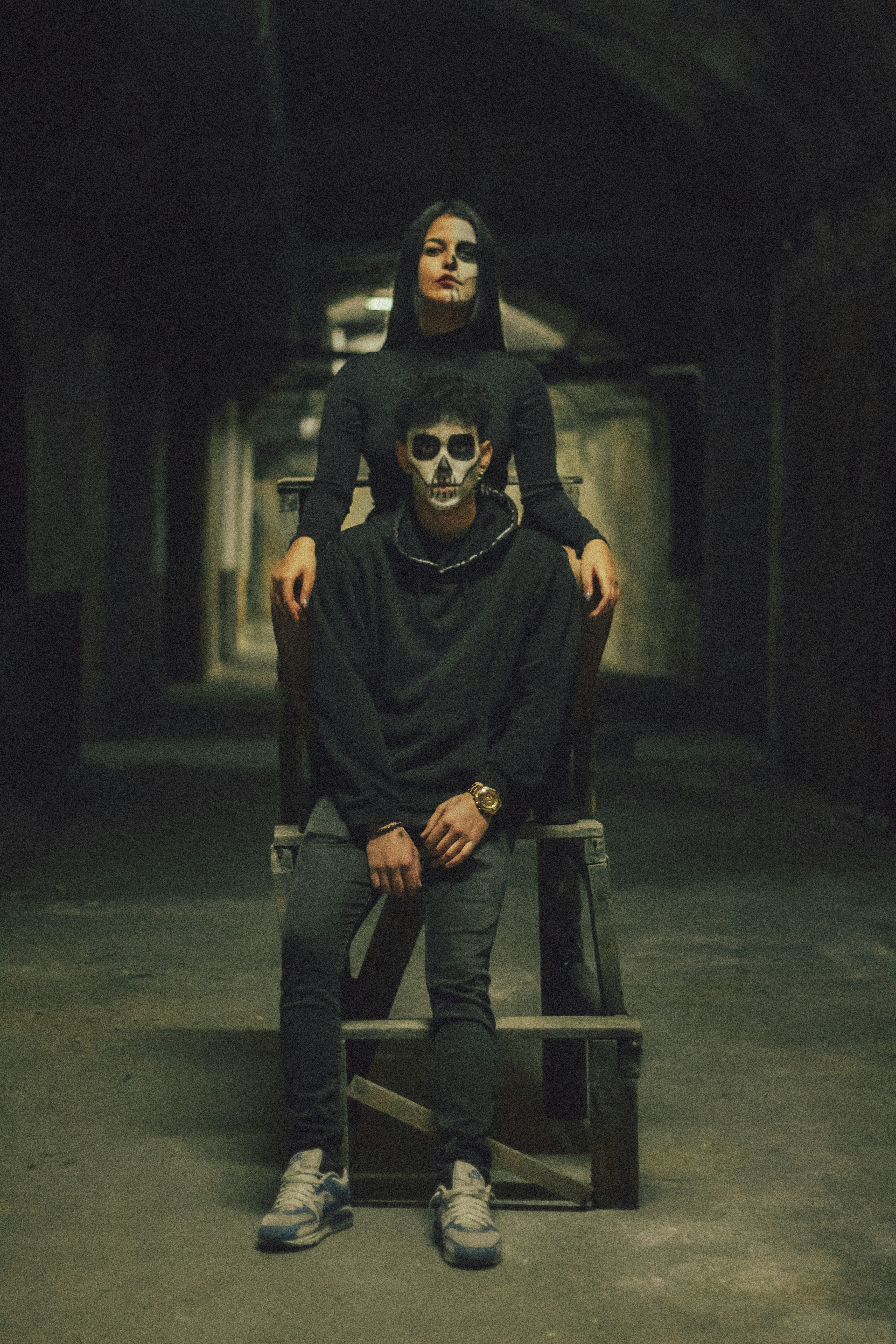 a woman sitting on top of a chair next to a man