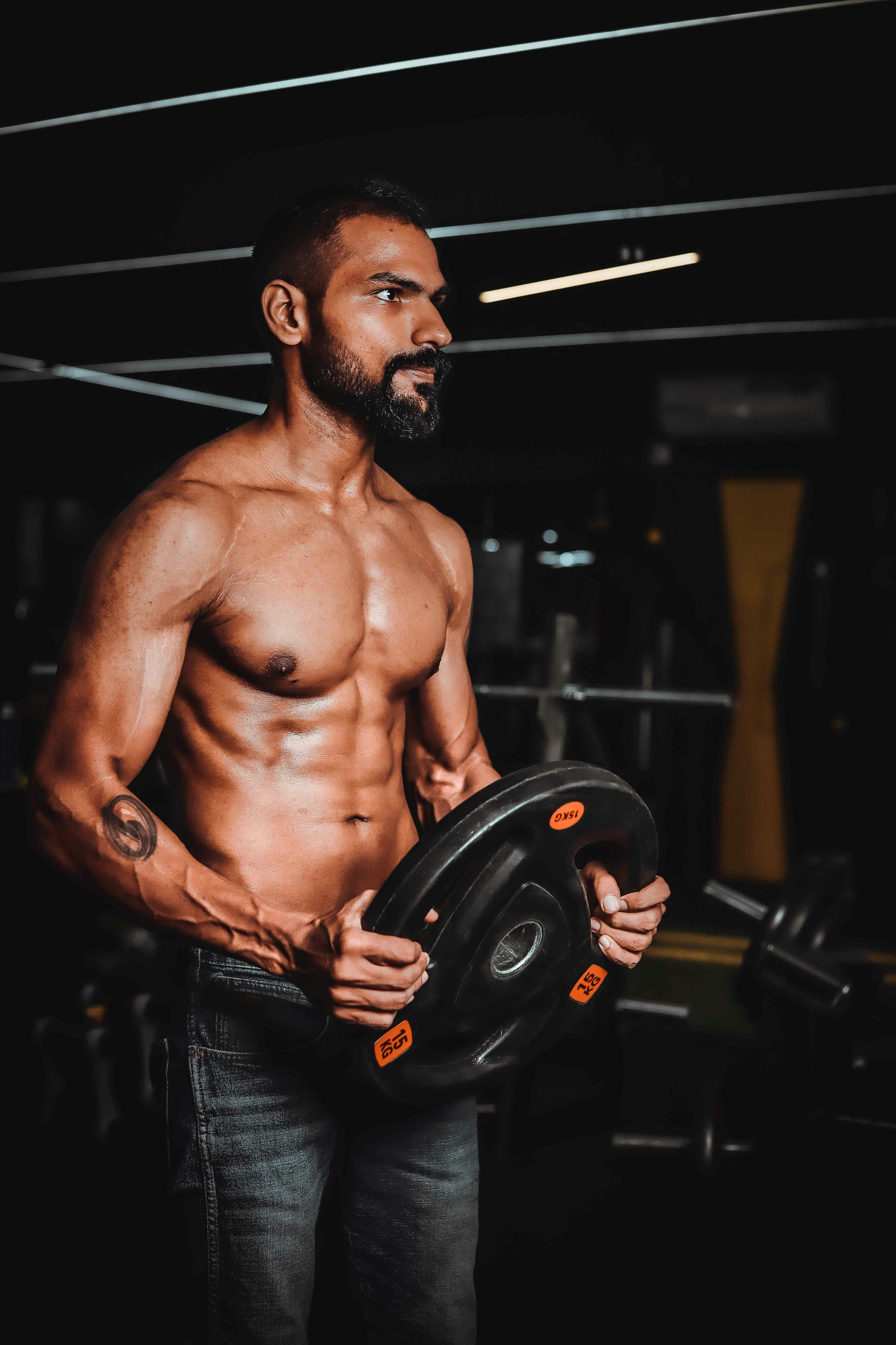 A shirtless man holding a dumb machine photo – Free Human Image on Unsplash