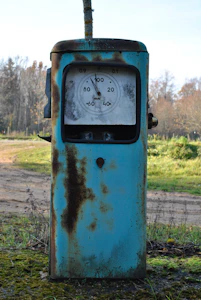 Rust-Blue Relic: A Lone Gas Pump Standing Guard in a Quiet Field