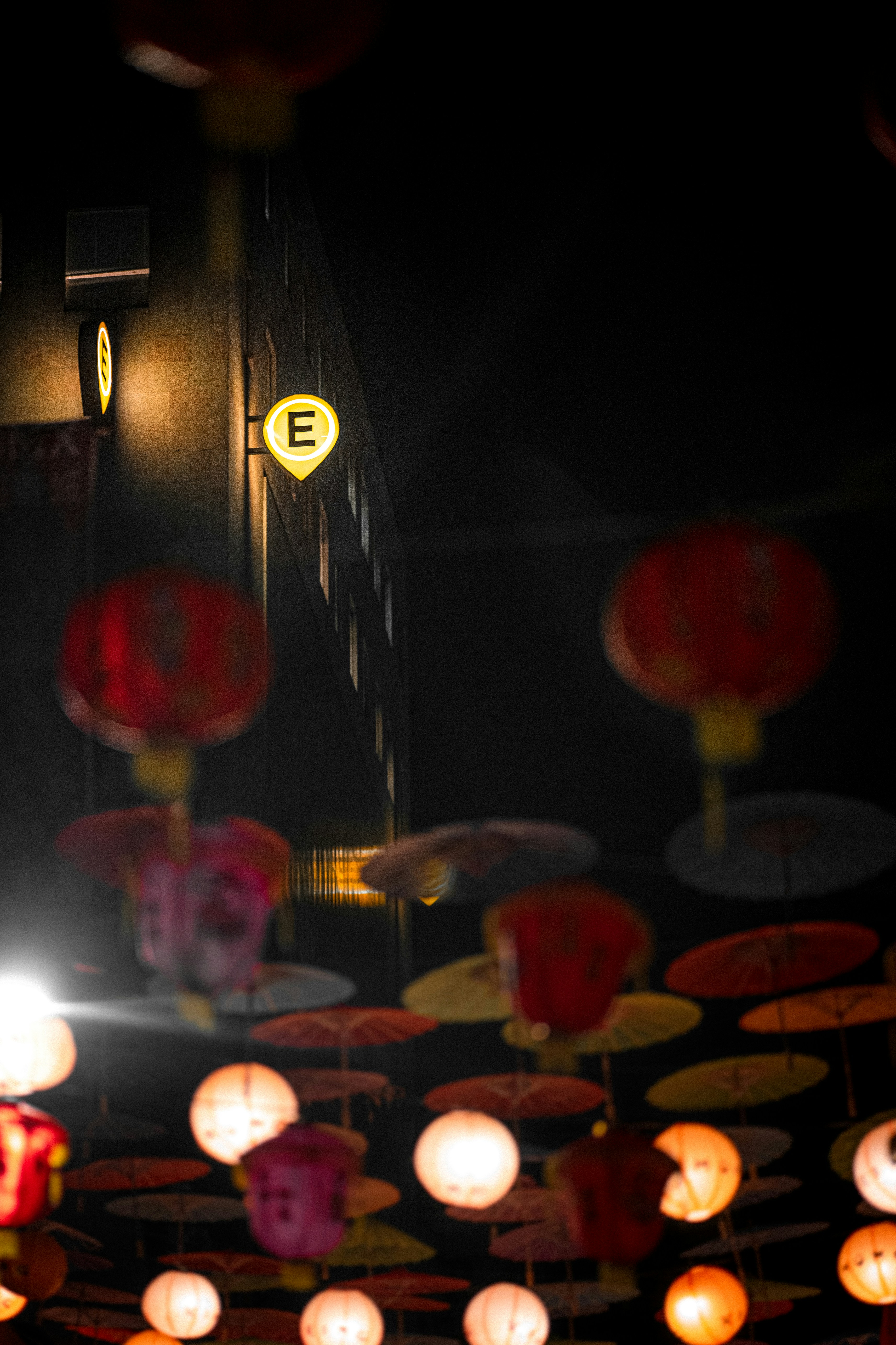 a group of red and yellow lanterns hanging from a ceiling