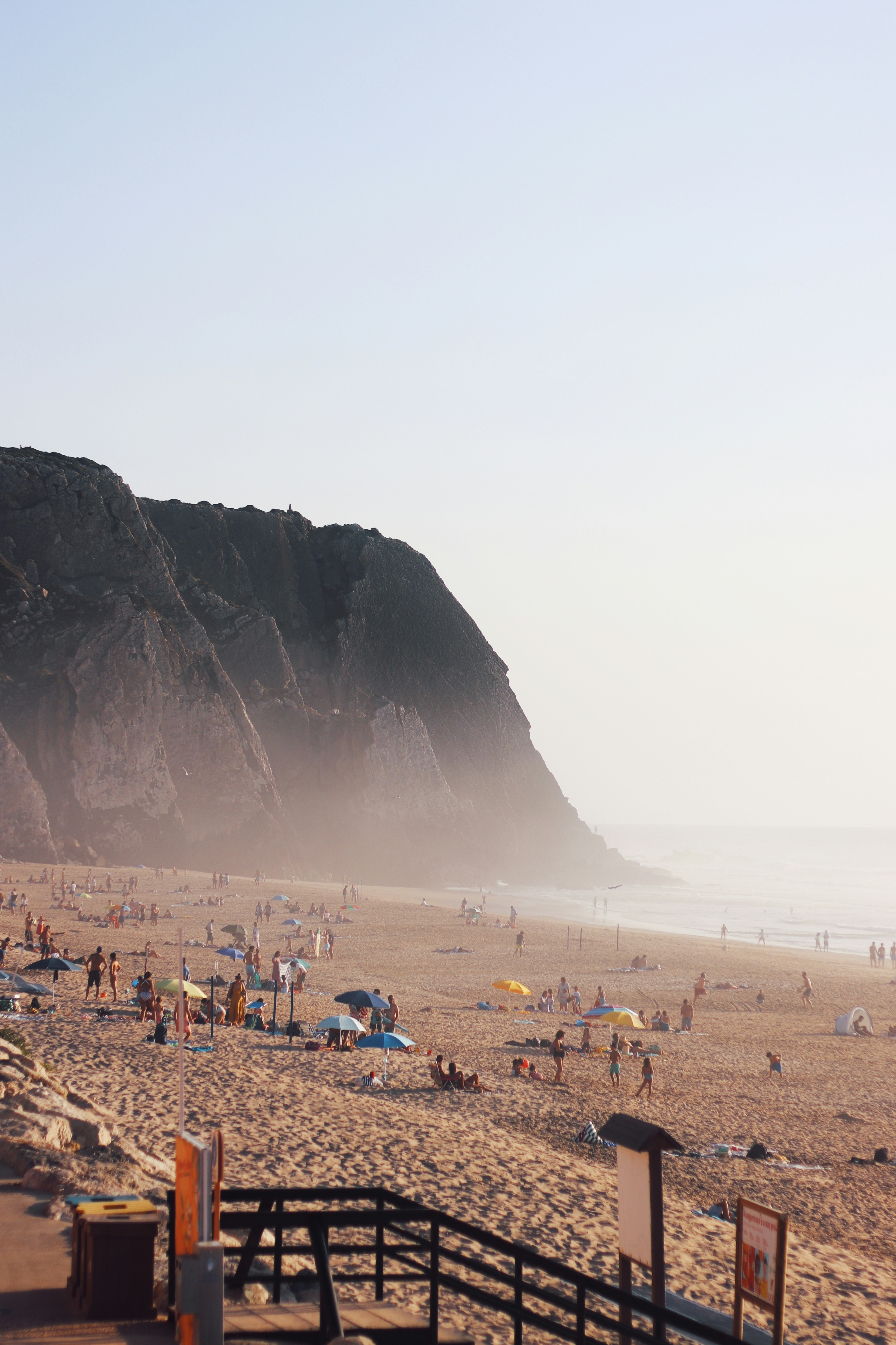 Cliffside Dawn: A Quiet Beach Beneath a Looming Monolith