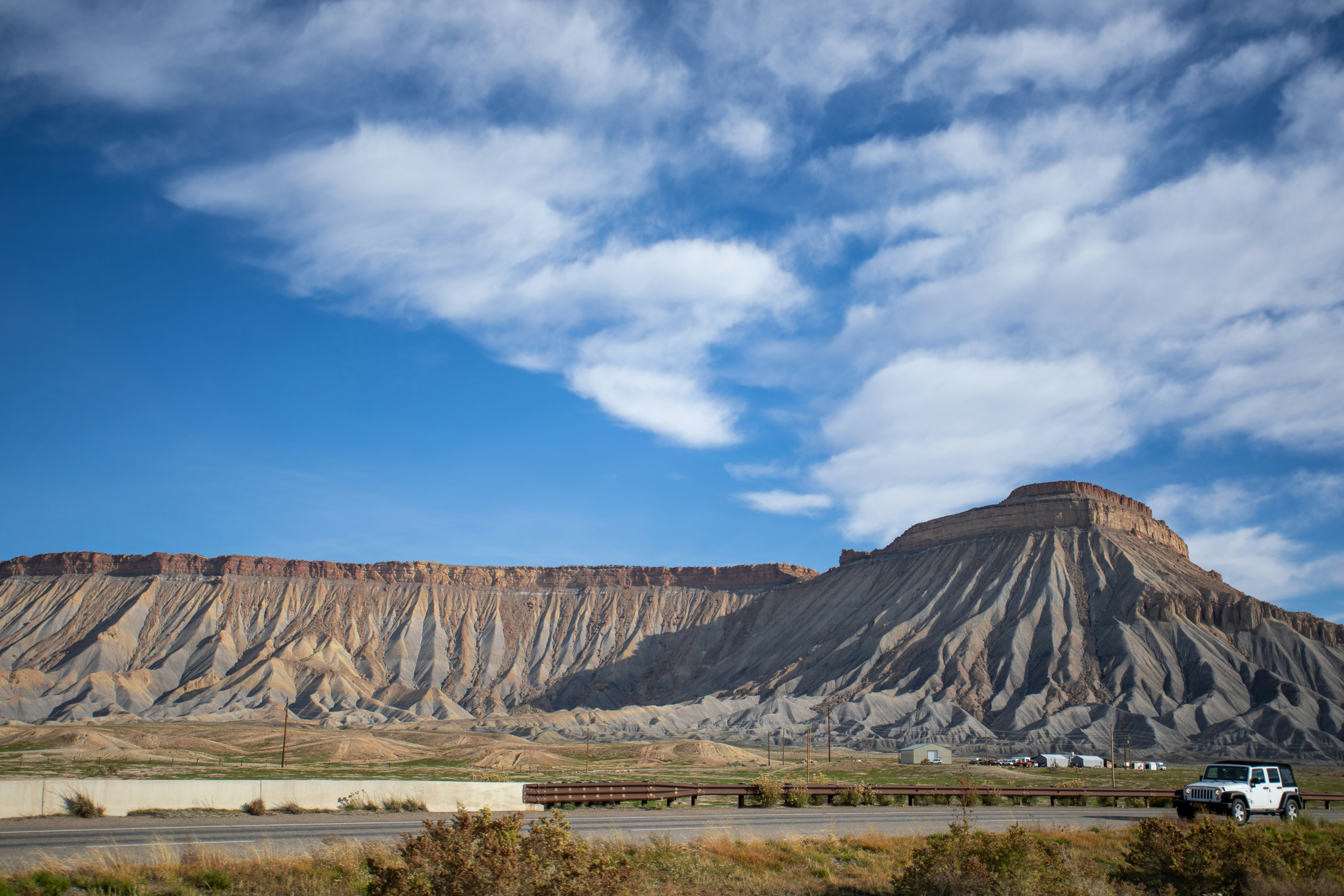 Lone SUV at the Foot of a Sculpted Desert Ridge
