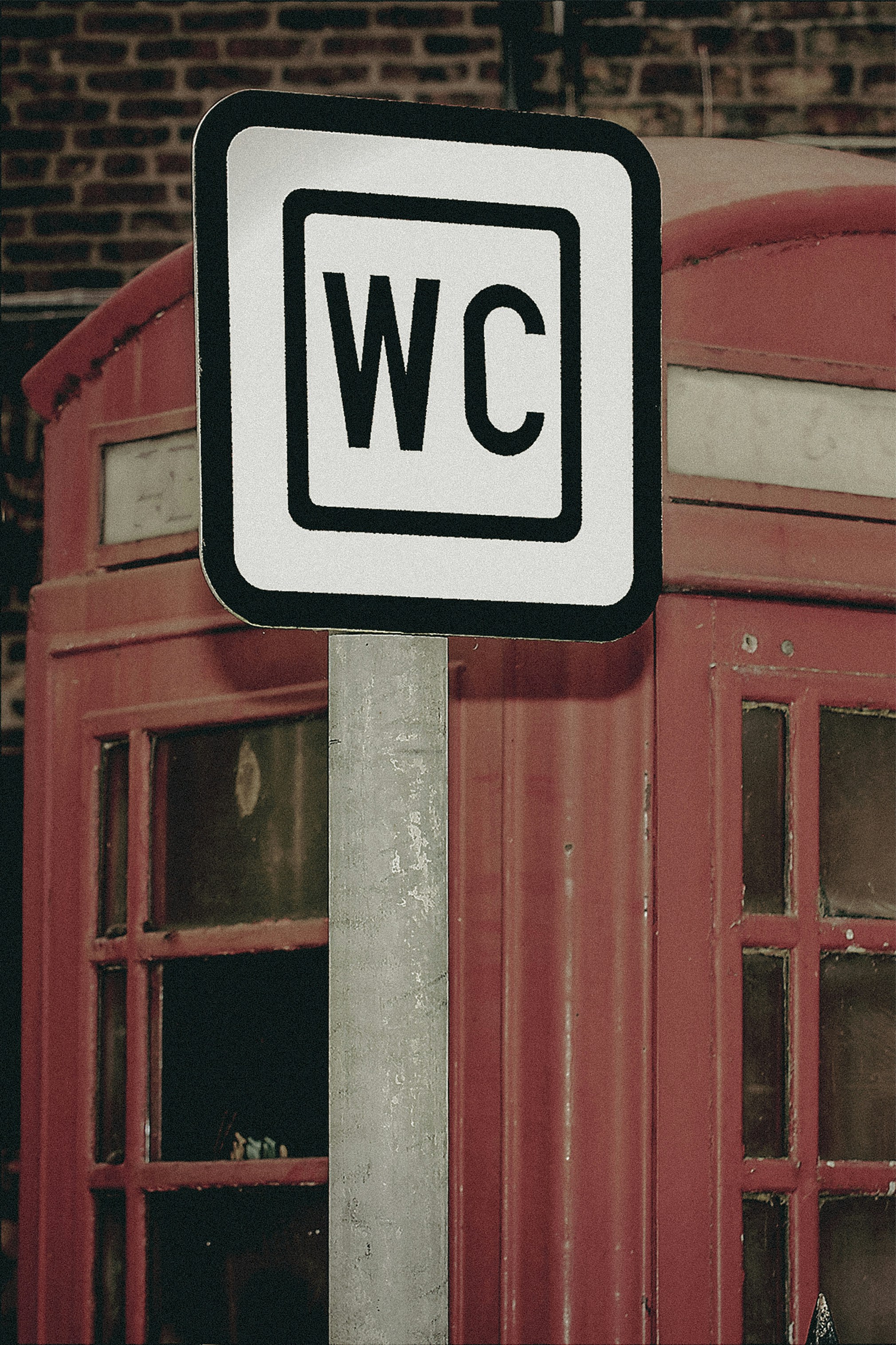 WC Sign in Front of a Crimson British Telephone Booth