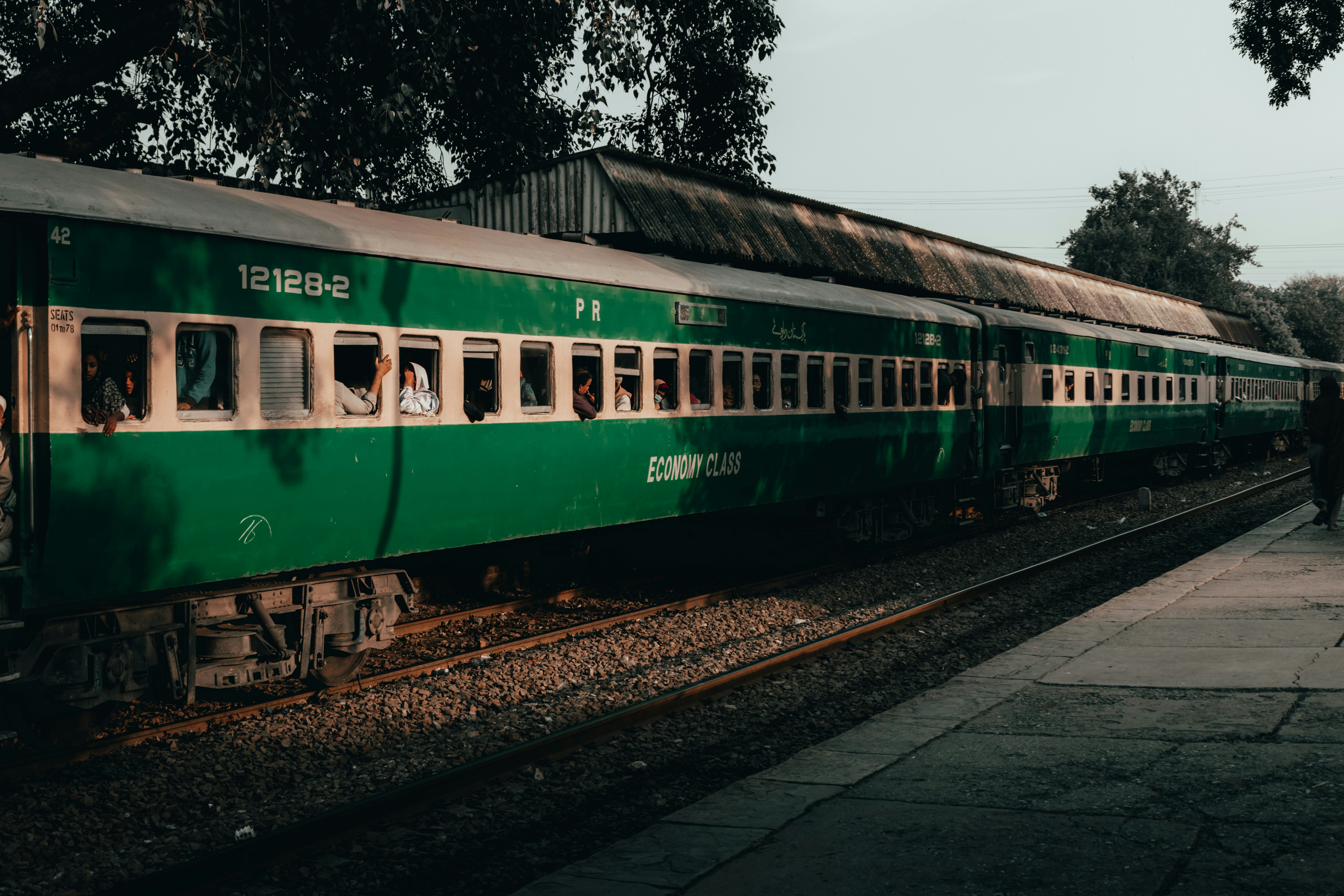 A green passenger train sitting on top of train tracks photo – Free ...