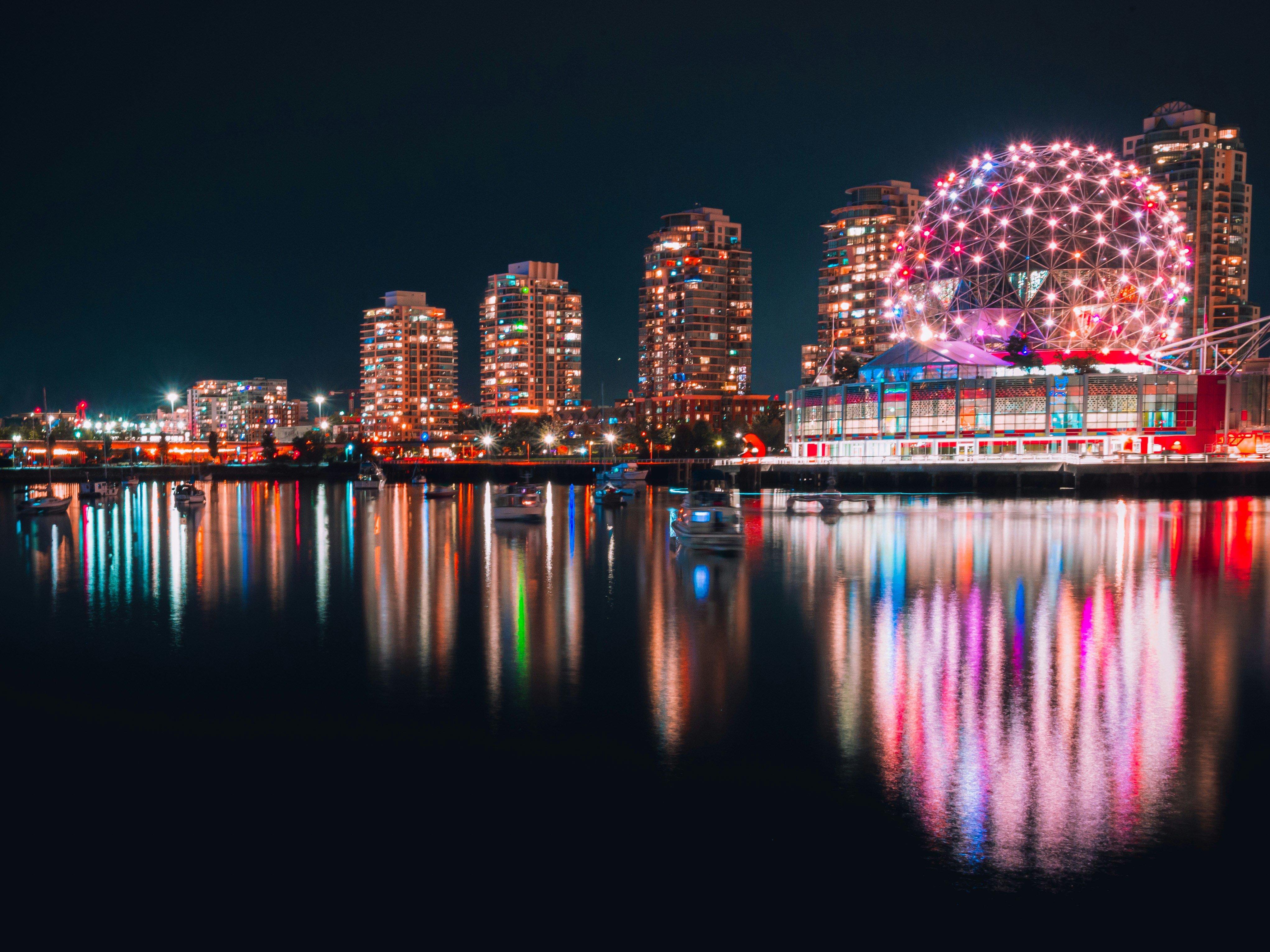 Neon Arc by the Water: City Lights on a Glassy Night